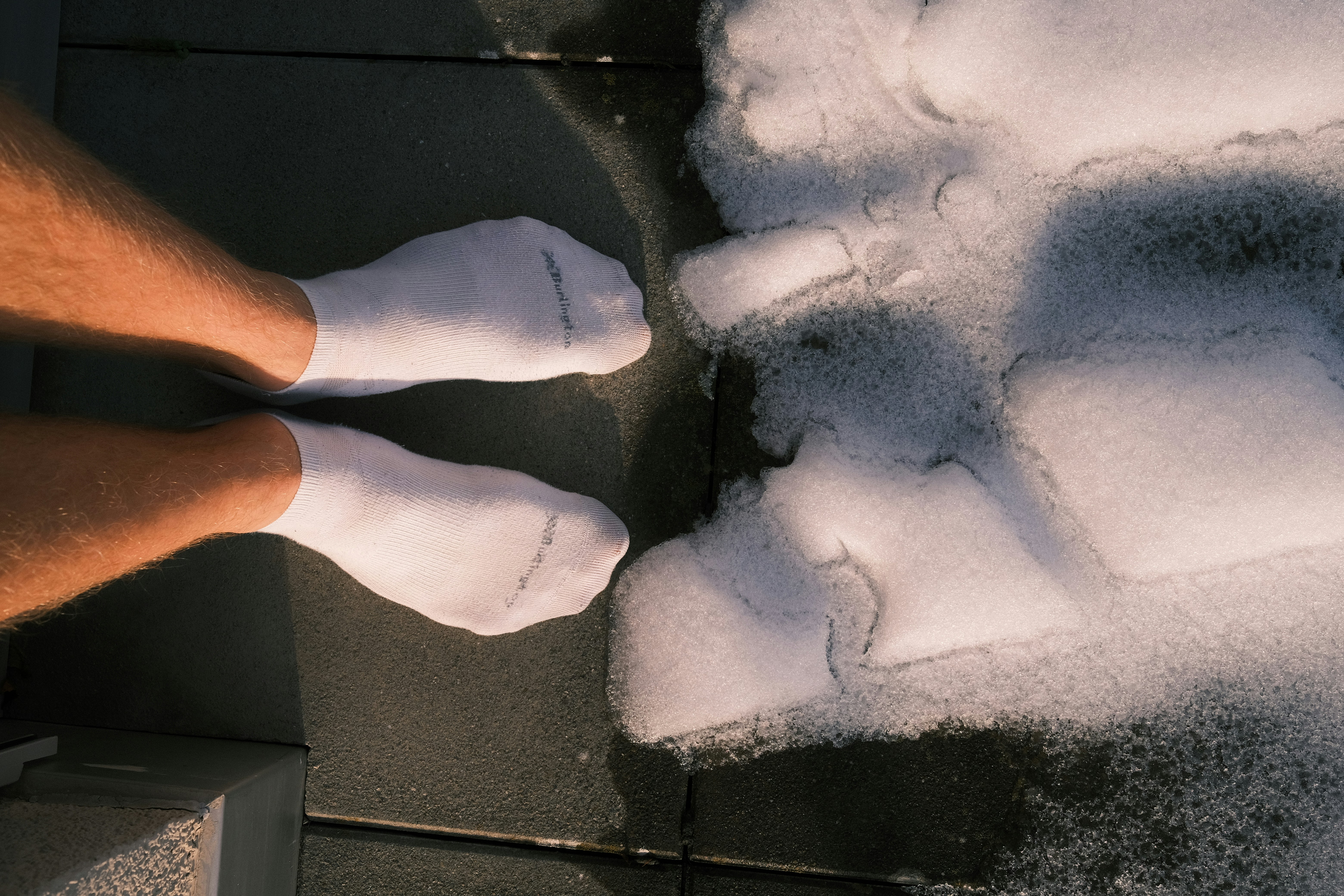 Warm White Socks on a Snow-dusted Deck: A Quiet Contrast