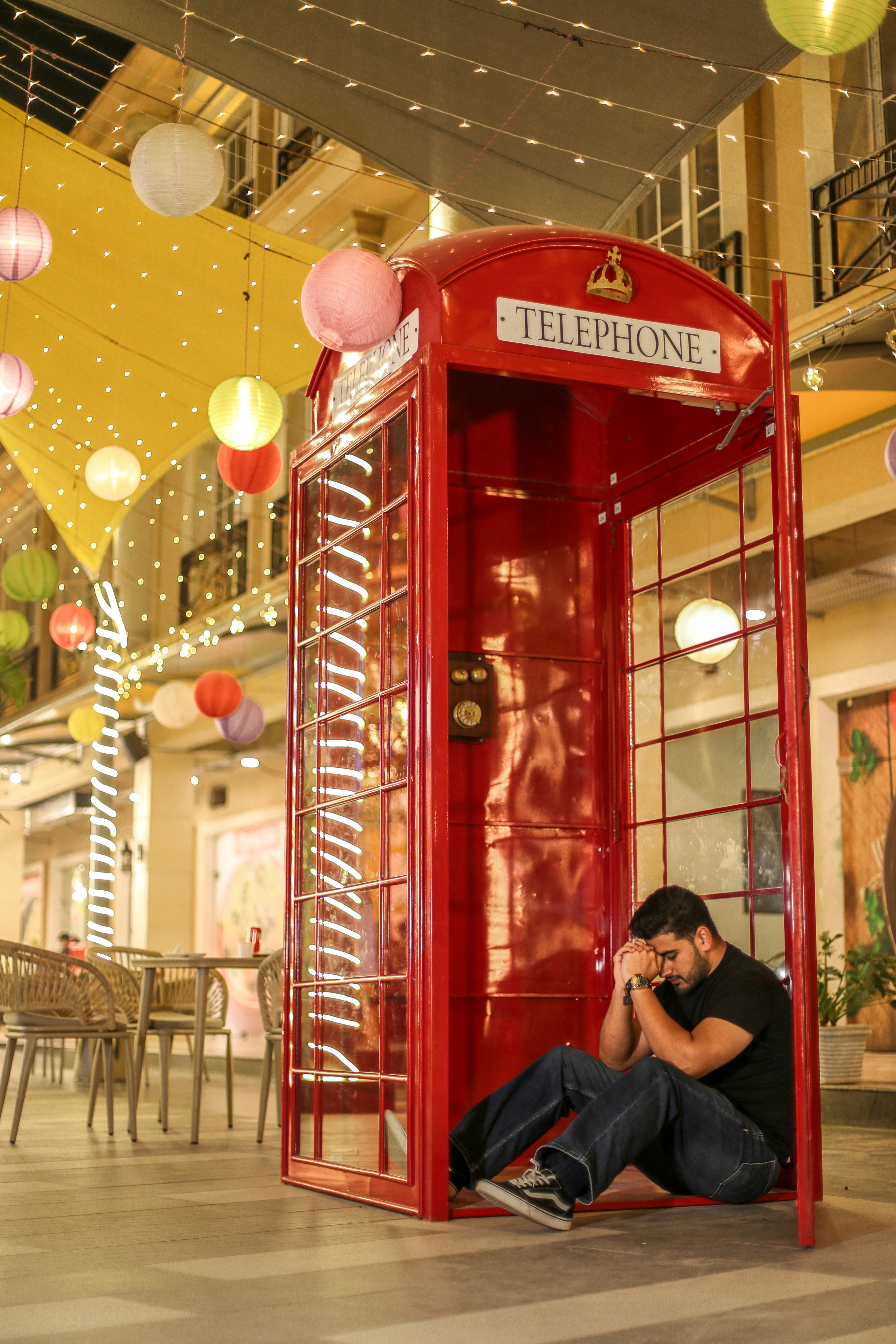 A man sitting in a red phone booth photo – Free Sad boy Image on Unsplash