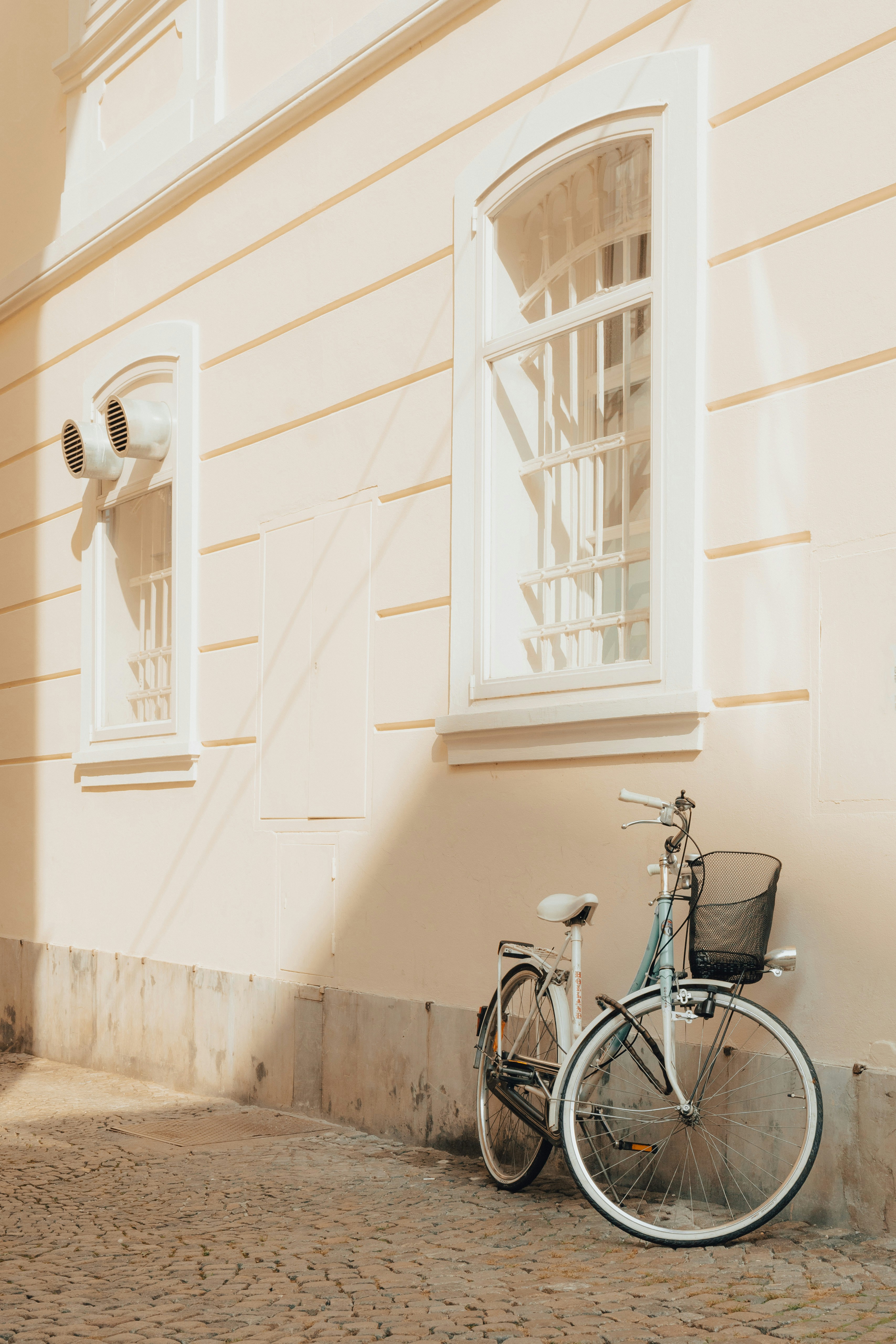 A bicycle is parked next to a building photo – Free Street photography ...