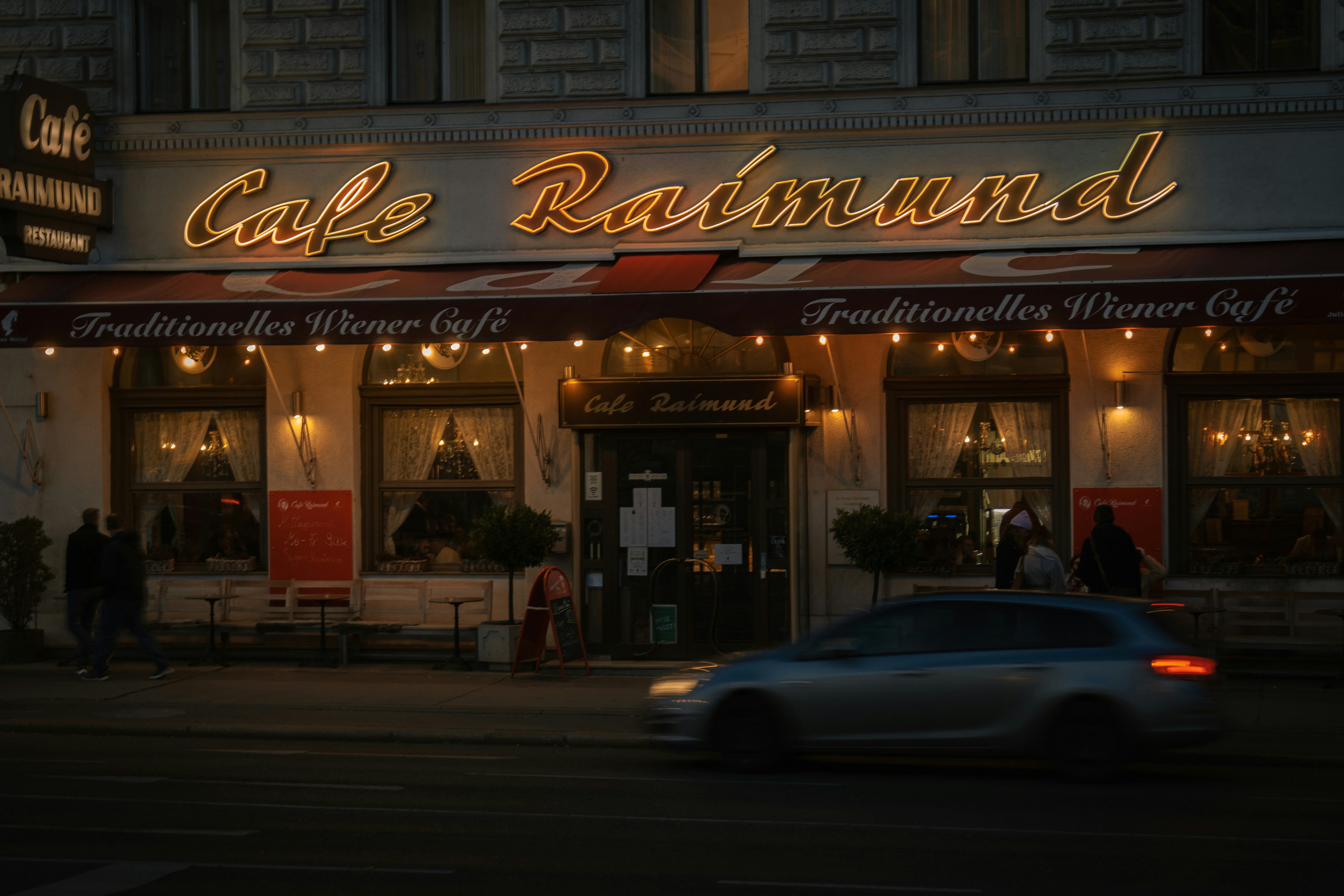 A car driving past a restaurant with lights on photo – Free Vienna ...