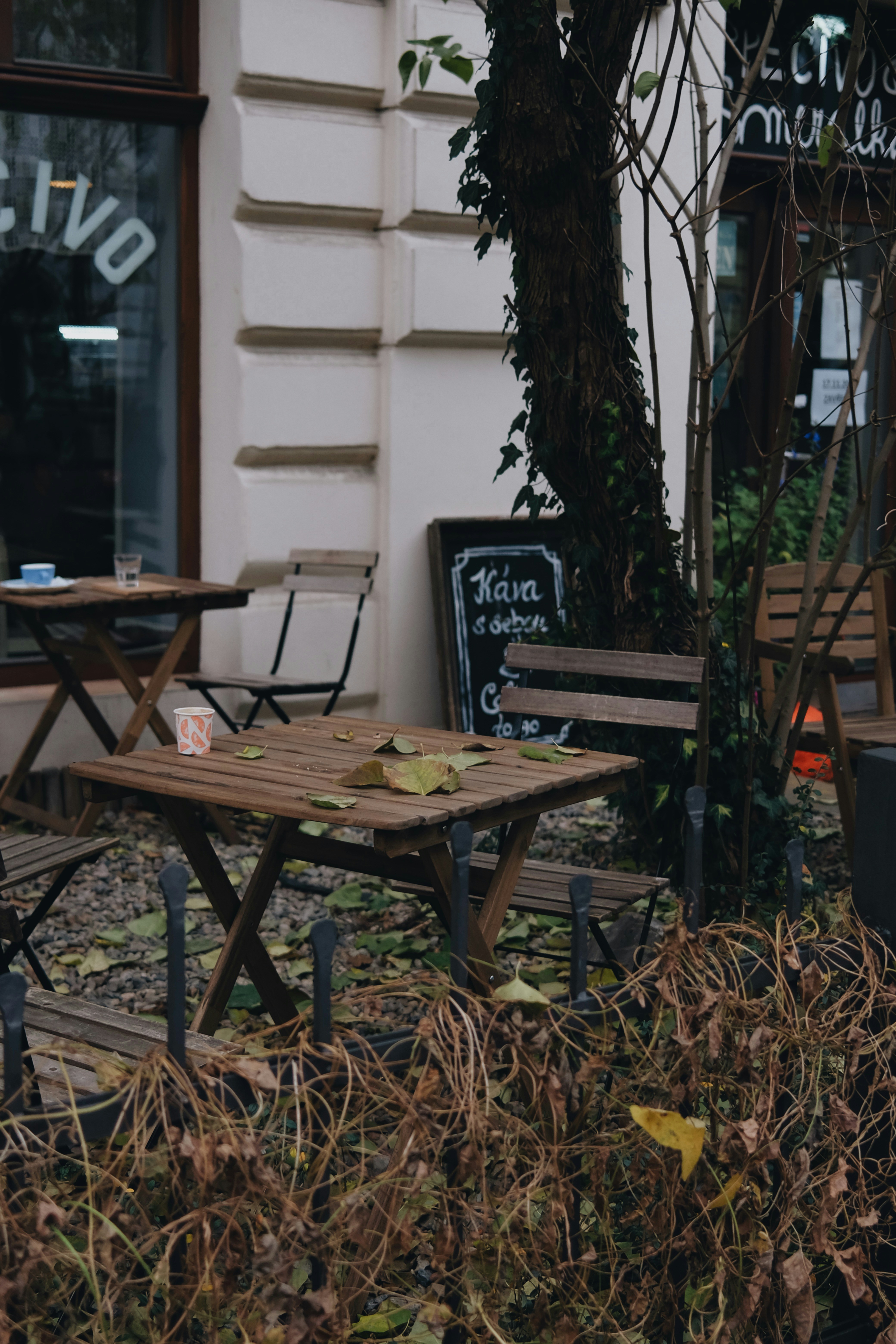 A couple of wooden tables sitting in front of a building photo – Free ...