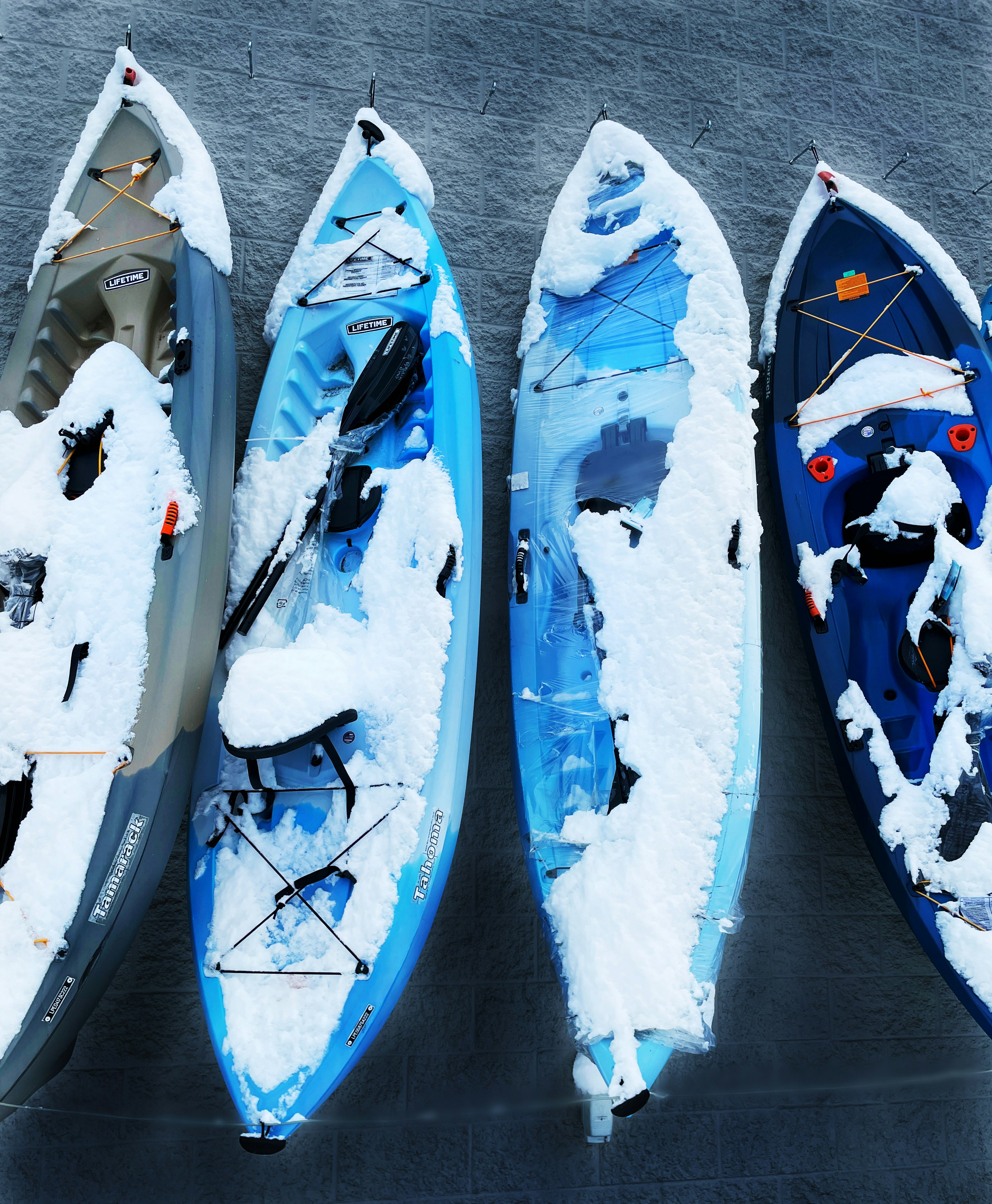 Three kayaks covered in snow sitting next to each other photo – Free ...