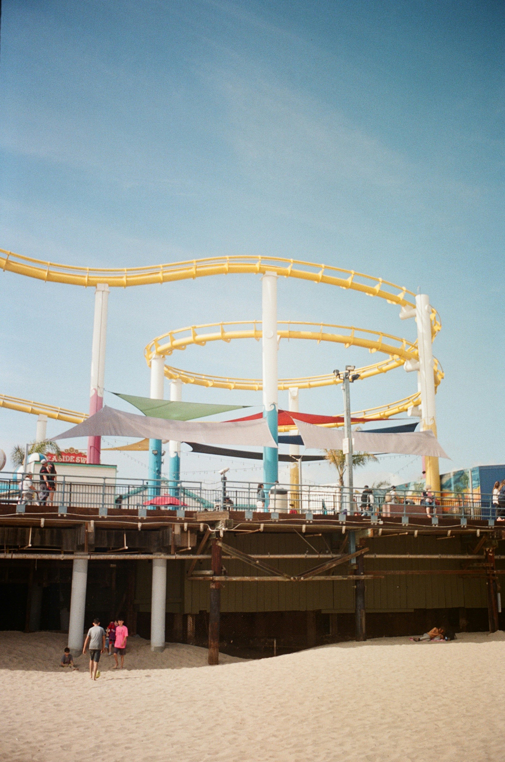 A roller coaster on a beach with people walking around photo – Free ...