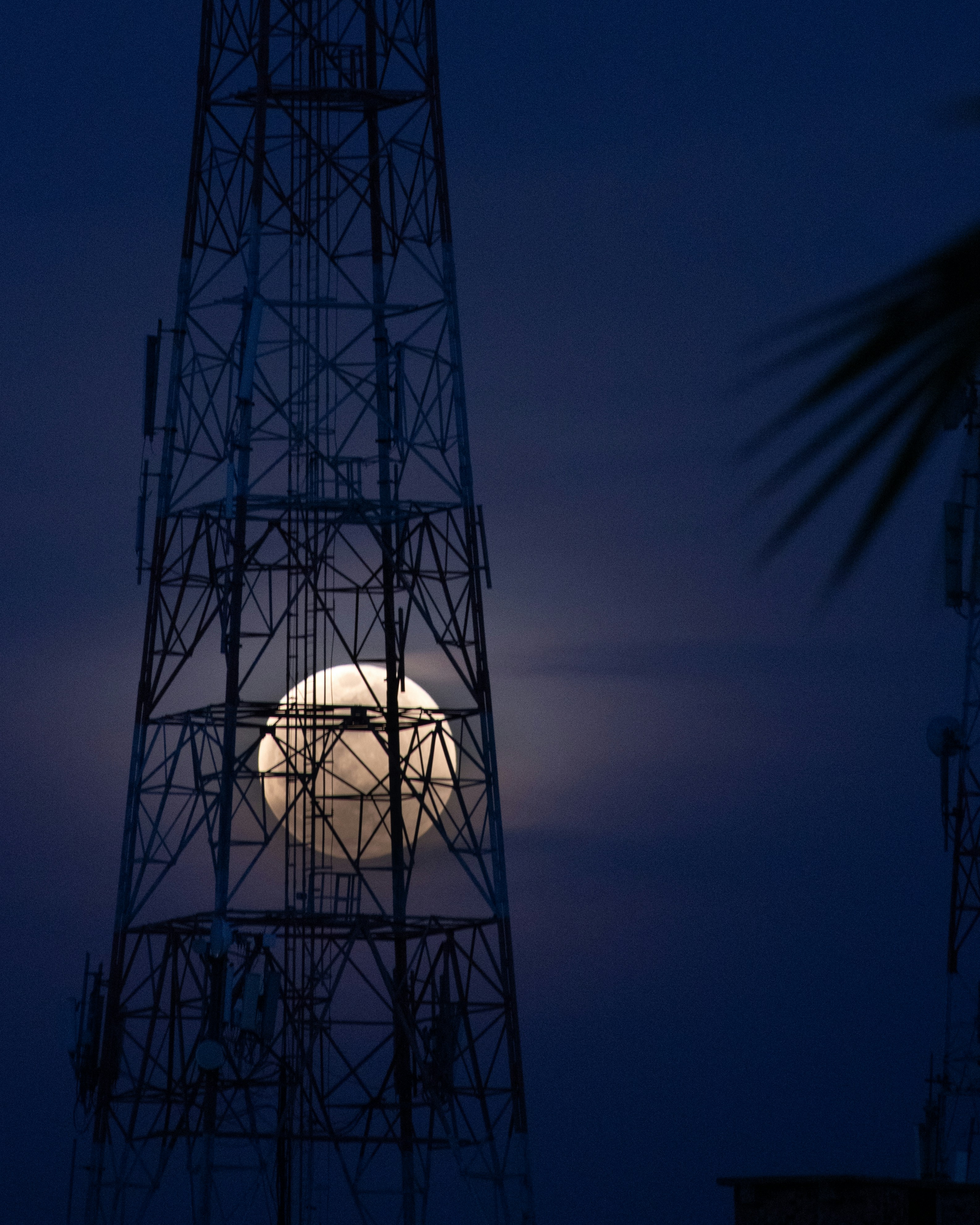 A full moon is seen behind a tower photo – Free Nature Image on Unsplash