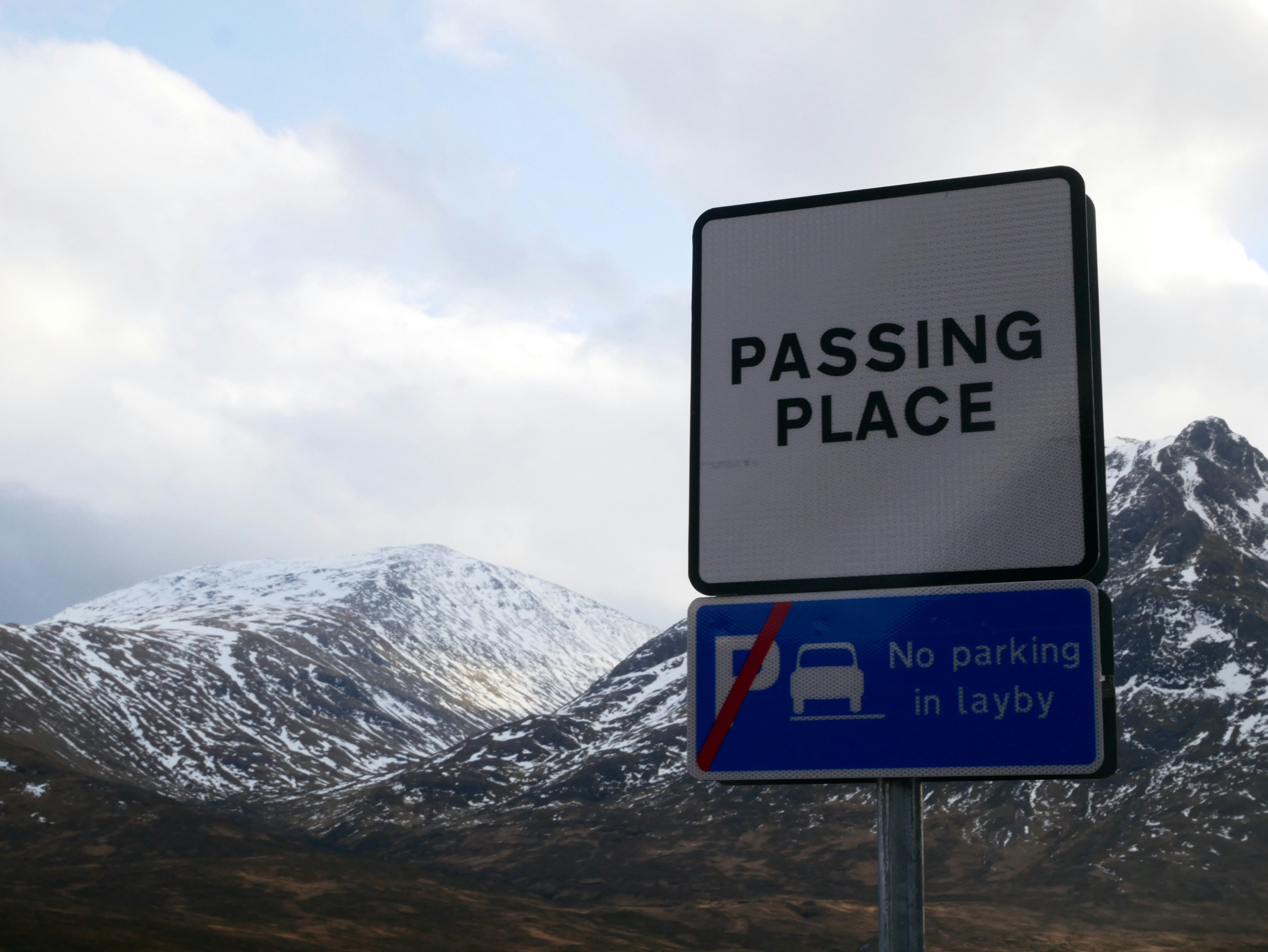 Passing Place Sign Anchoring a Snow-Dusted Highland Panorama