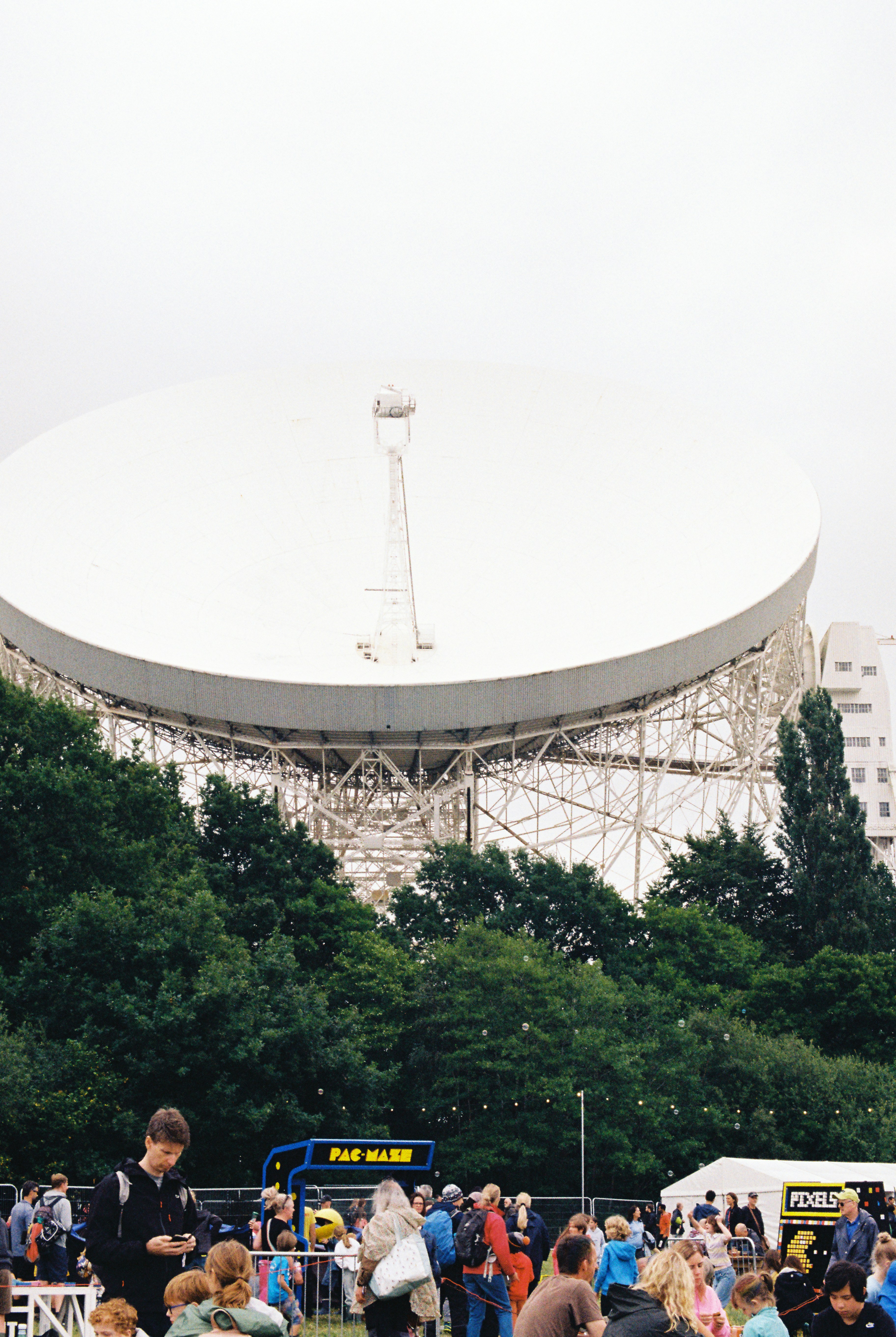 A crowd of people sitting around a large satellite dish photo – Free ...