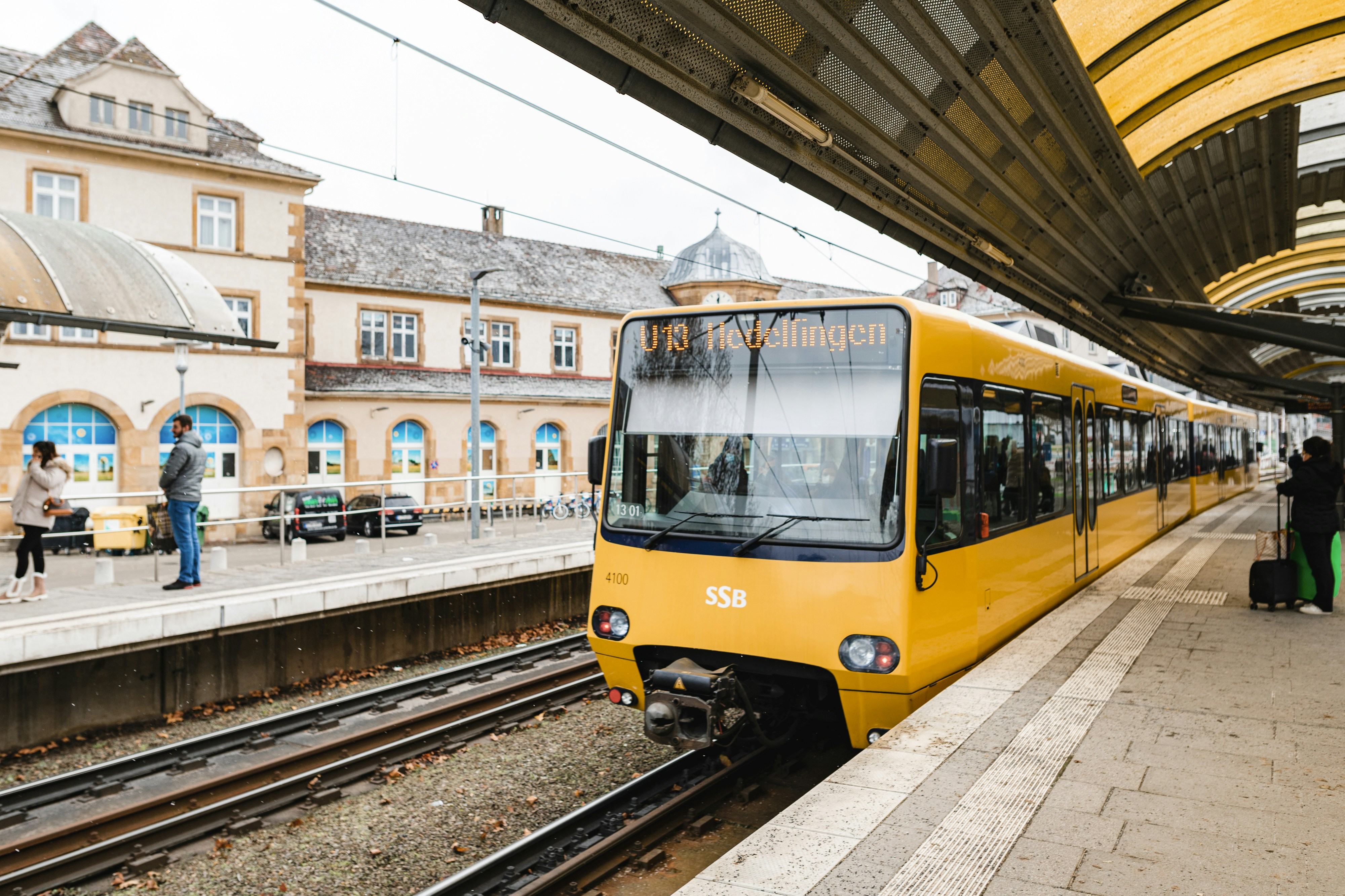 A yellow train pulling into a train station photo – Free Stuttgart ...