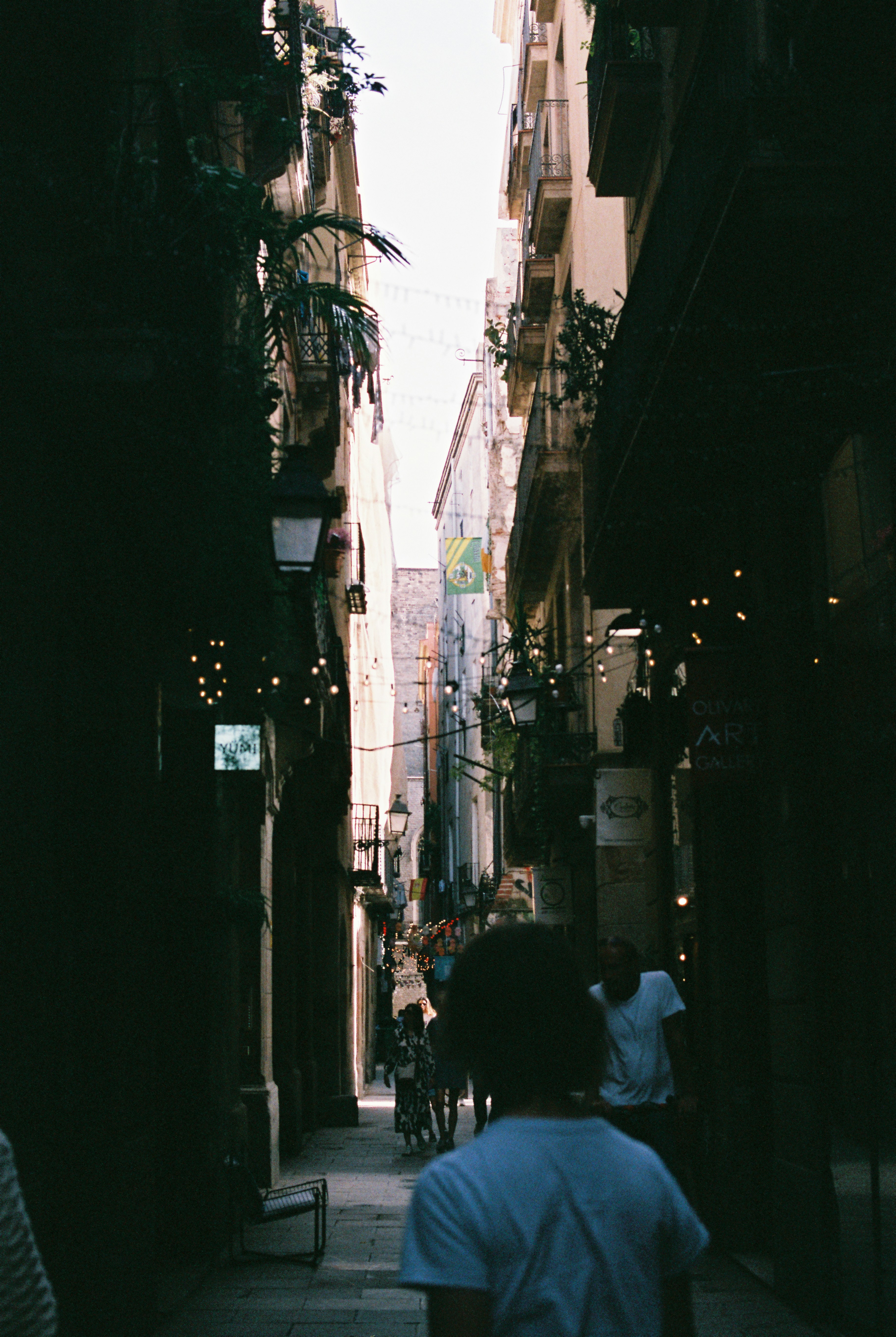 A person walking down a narrow city street photo – Free Film ...