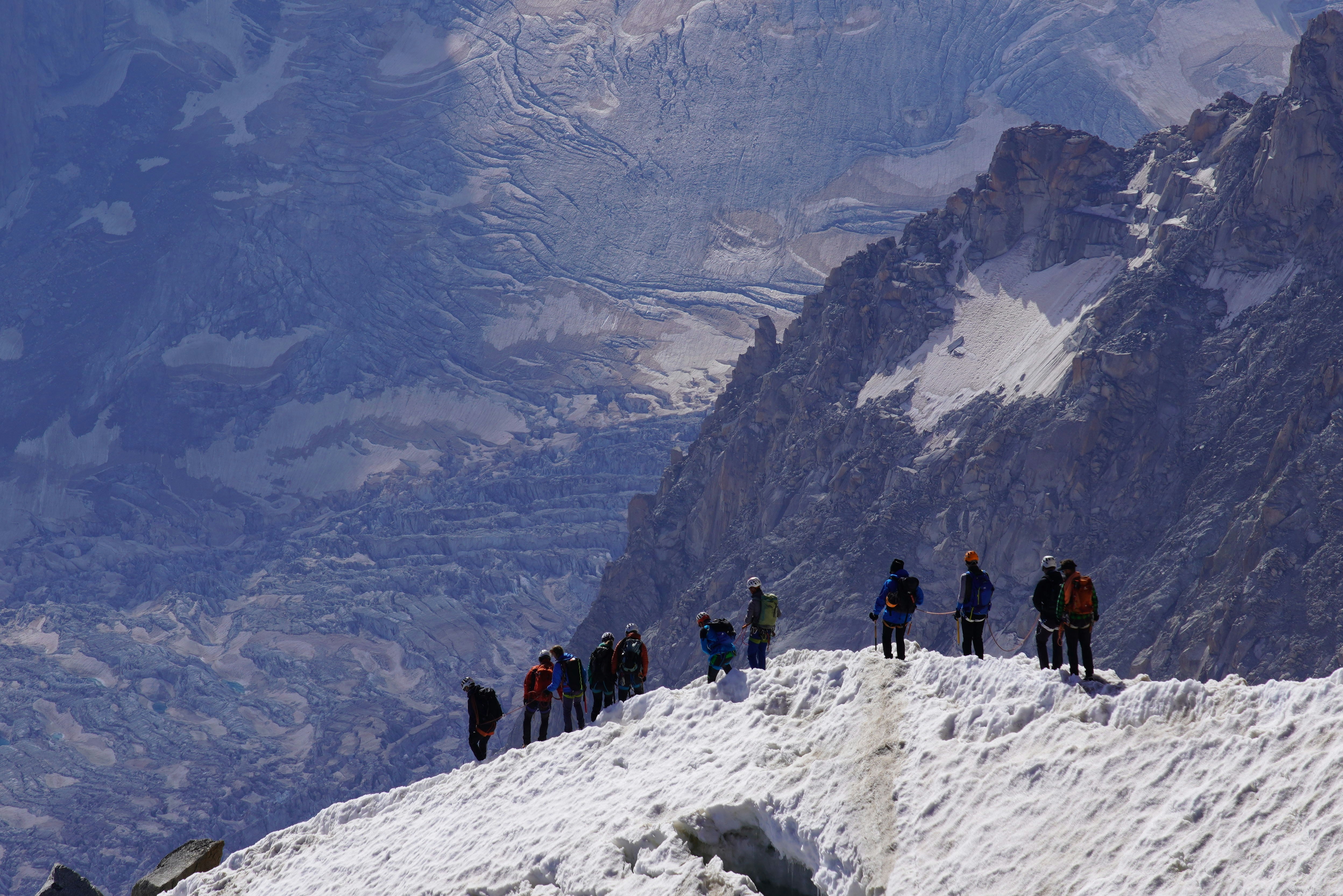 Climbers on a frost-kissed ridge beneath jagged alpine walls