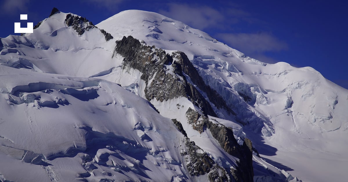 Une Grande Montagne Couverte De Neige Sous Un Ciel Bleu Photo Photo