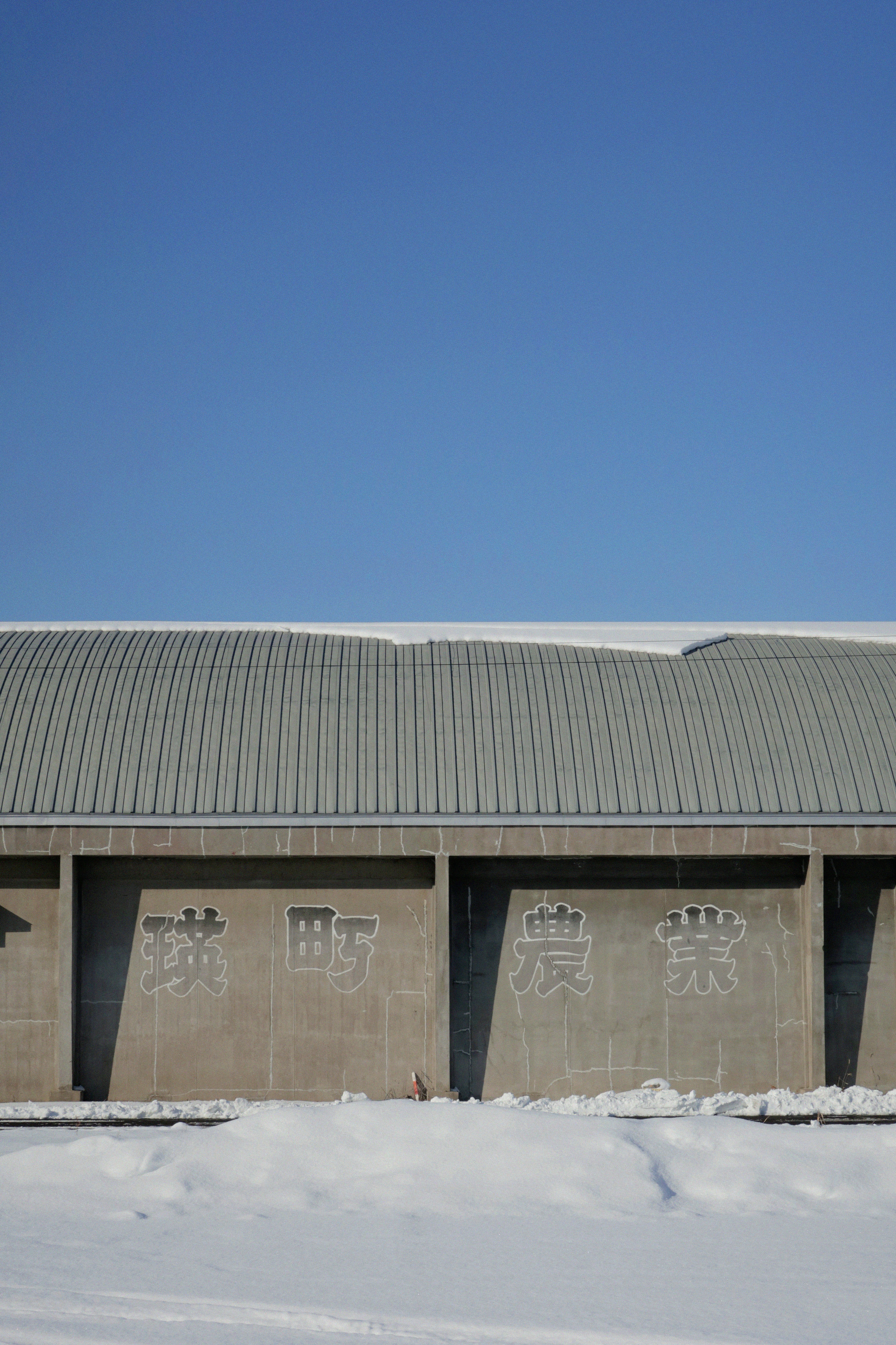 Winter Glyphs Under a Pristine Blue Sky on a Quiet Warehouse