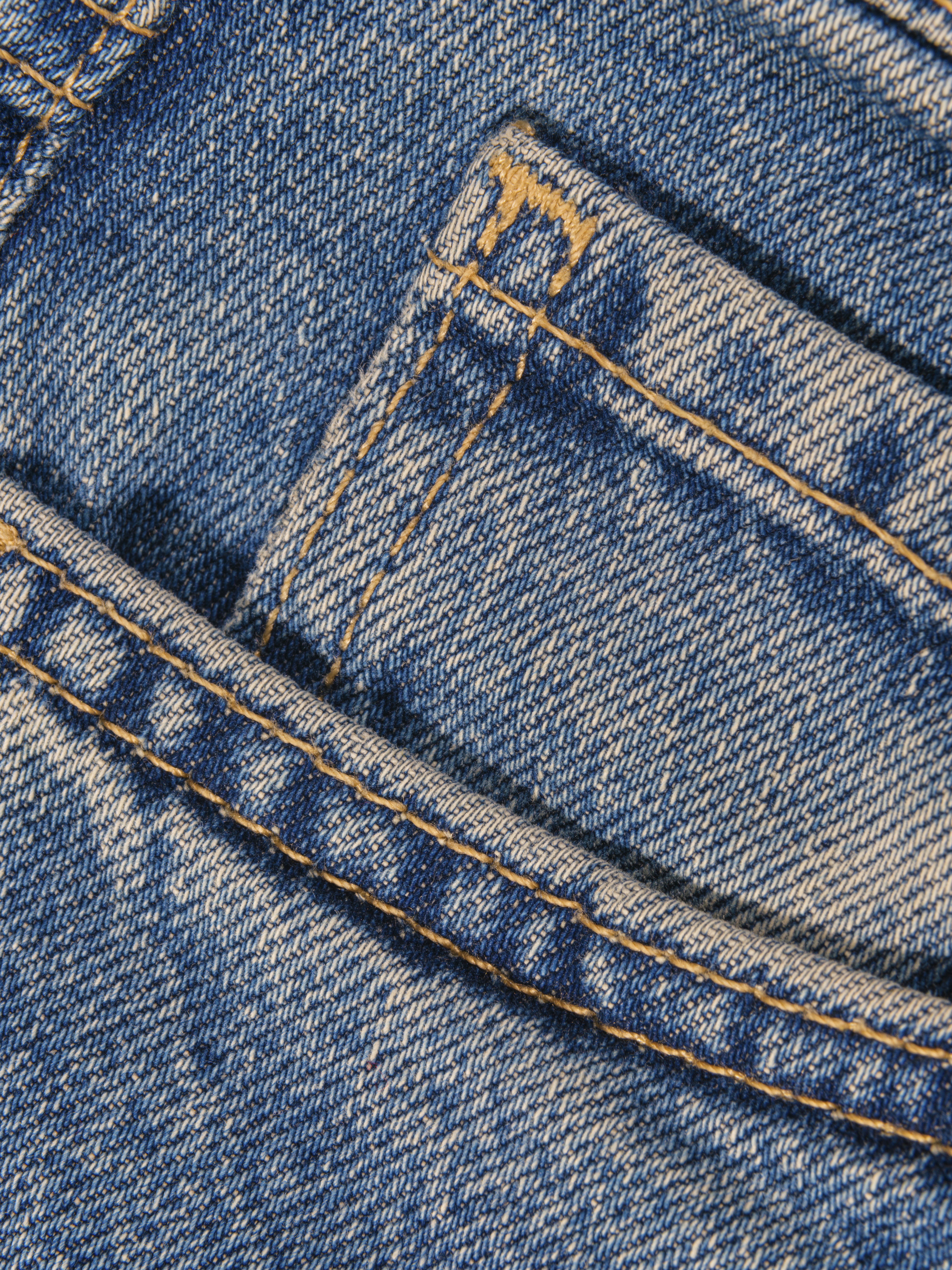 Jeans pocket | a close up of a pair of blue jeans