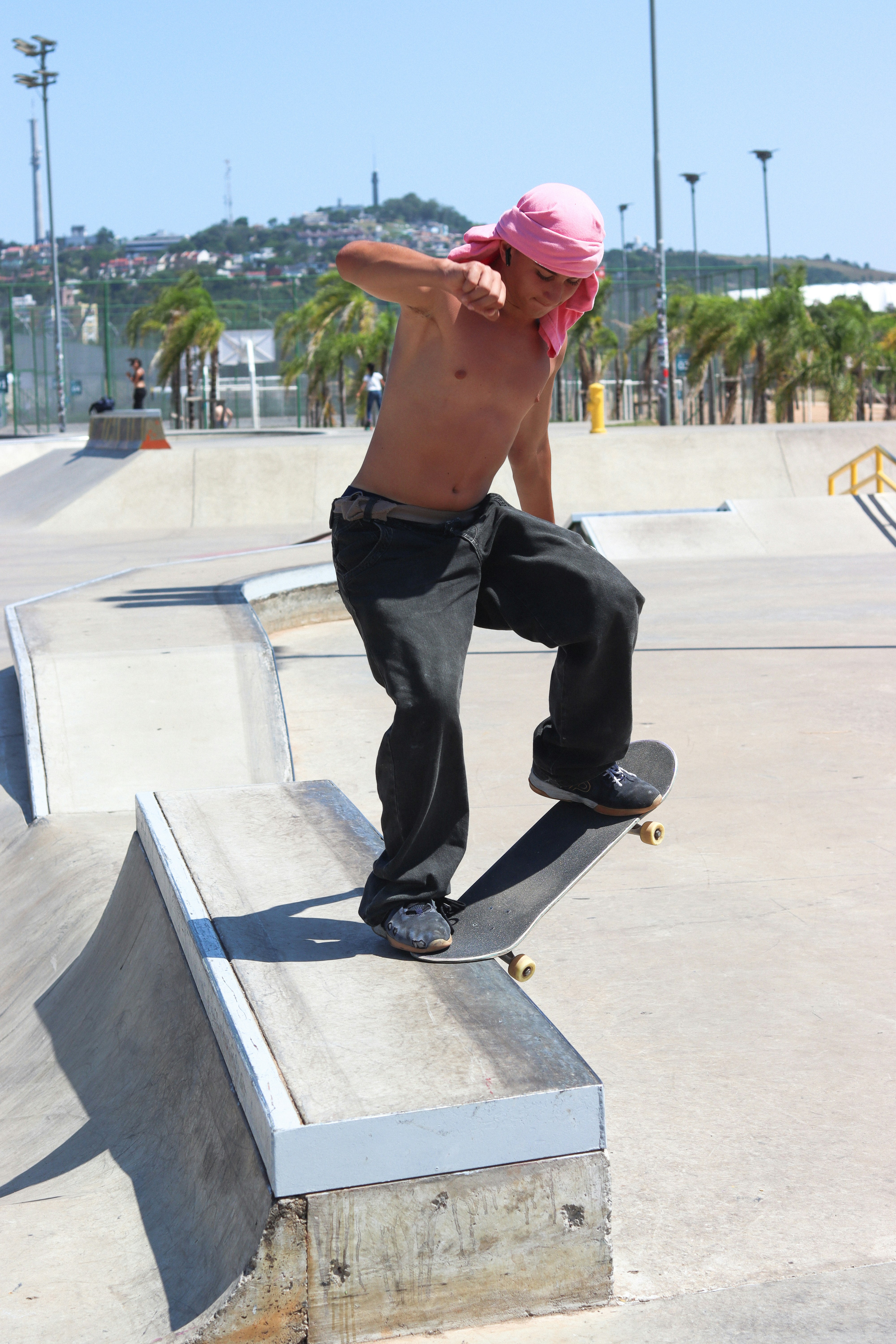 A shirtless man riding a skateboard at a skate park photo – Free Trick ...
