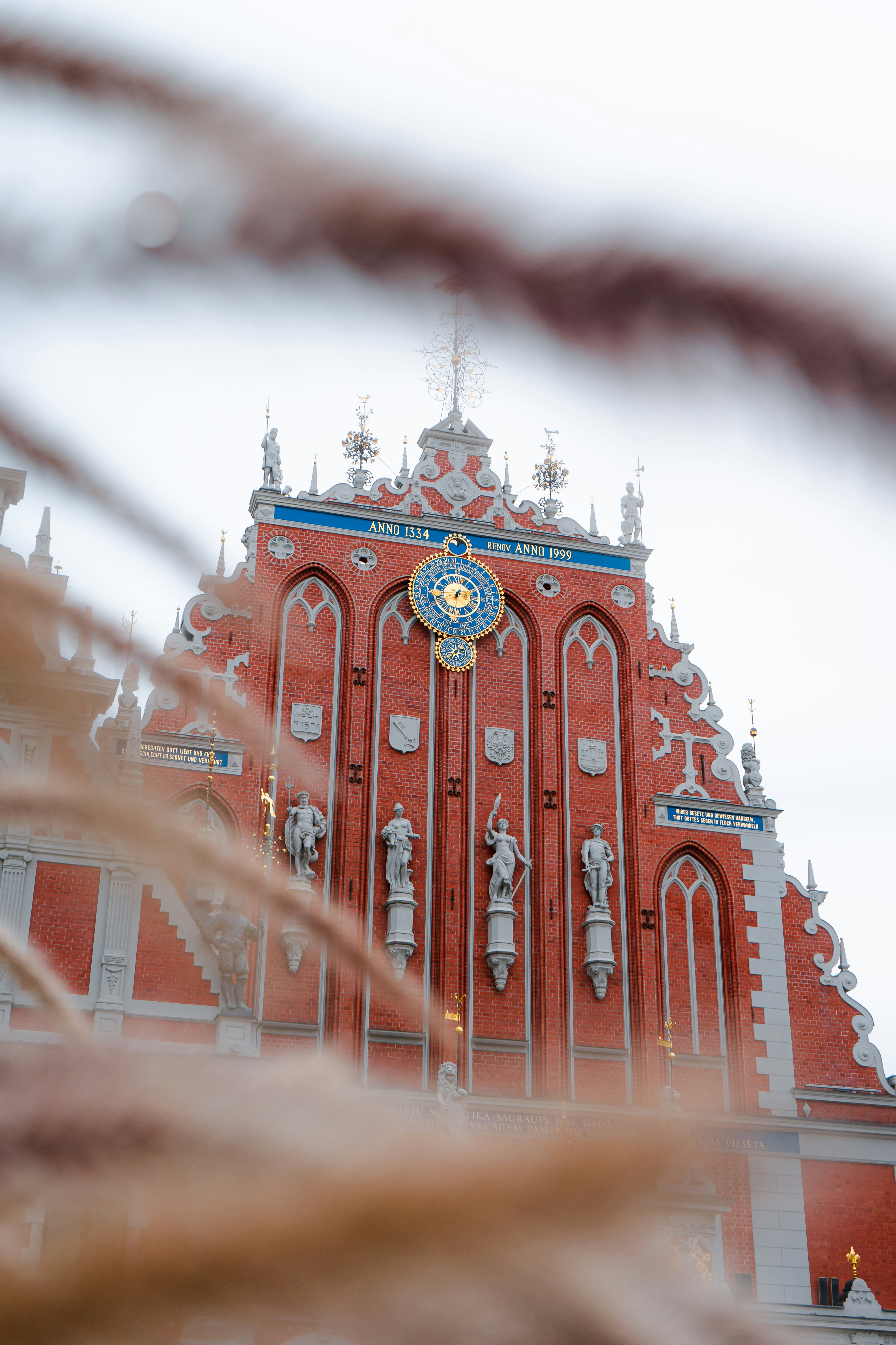 Clock Tower in Focus: Red Brick Facade Framed by Framing Branches