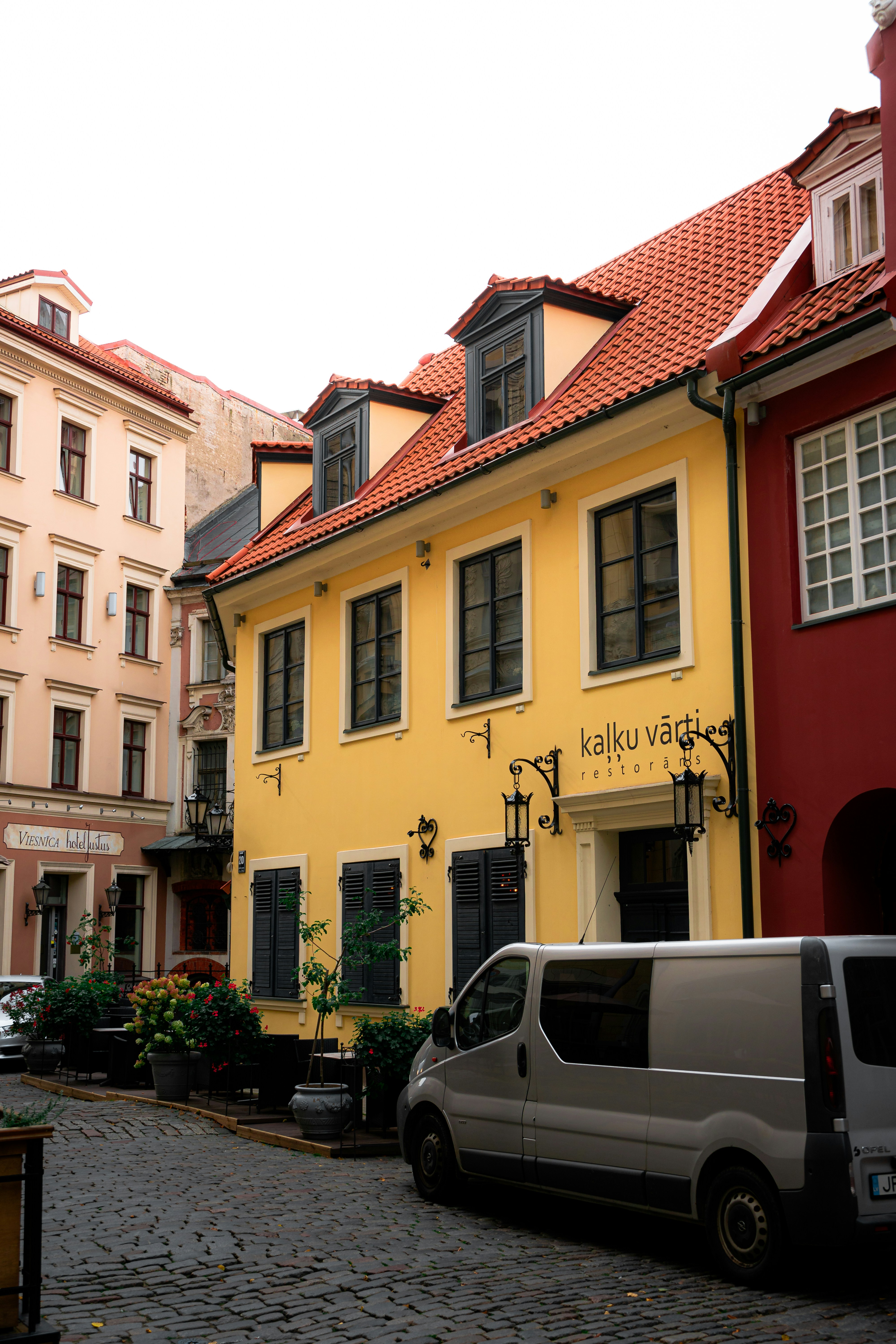 A van parked in front of a yellow building photo – Free Riga Image on ...