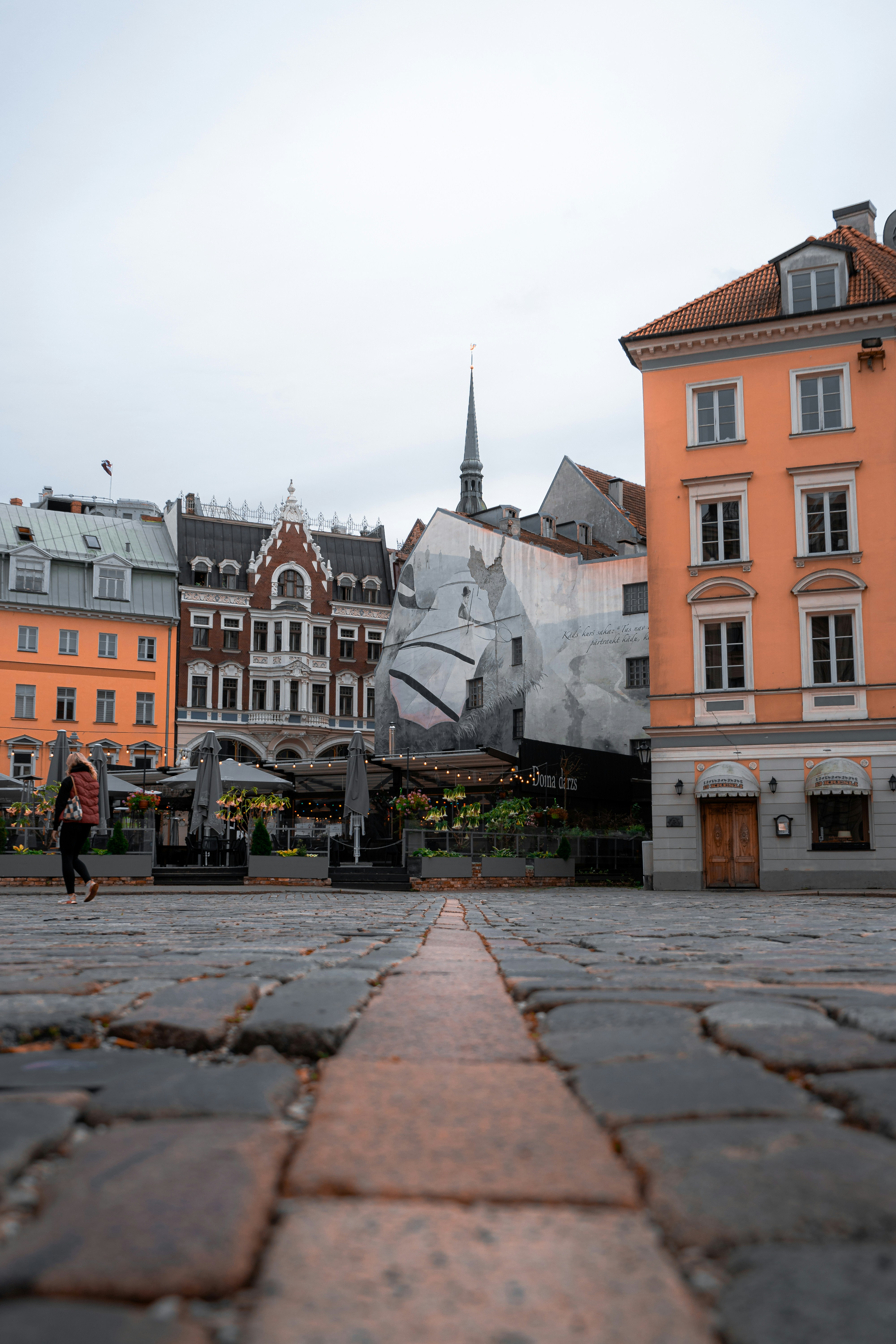 Cobblestone Corridor to a Modern Mural in a Pastel European Square