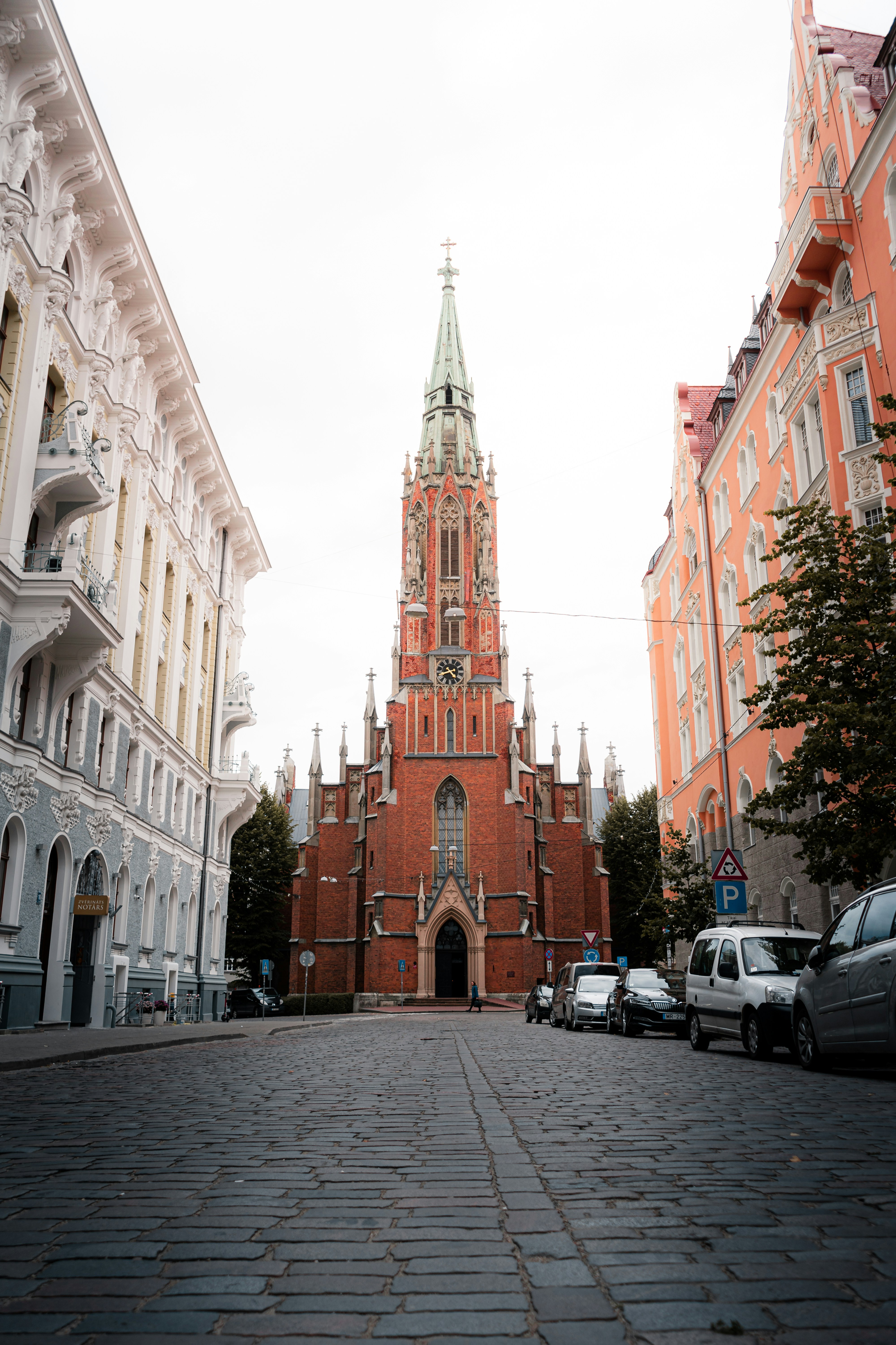 A large building with a steeple in the middle of a street photo – Free ...