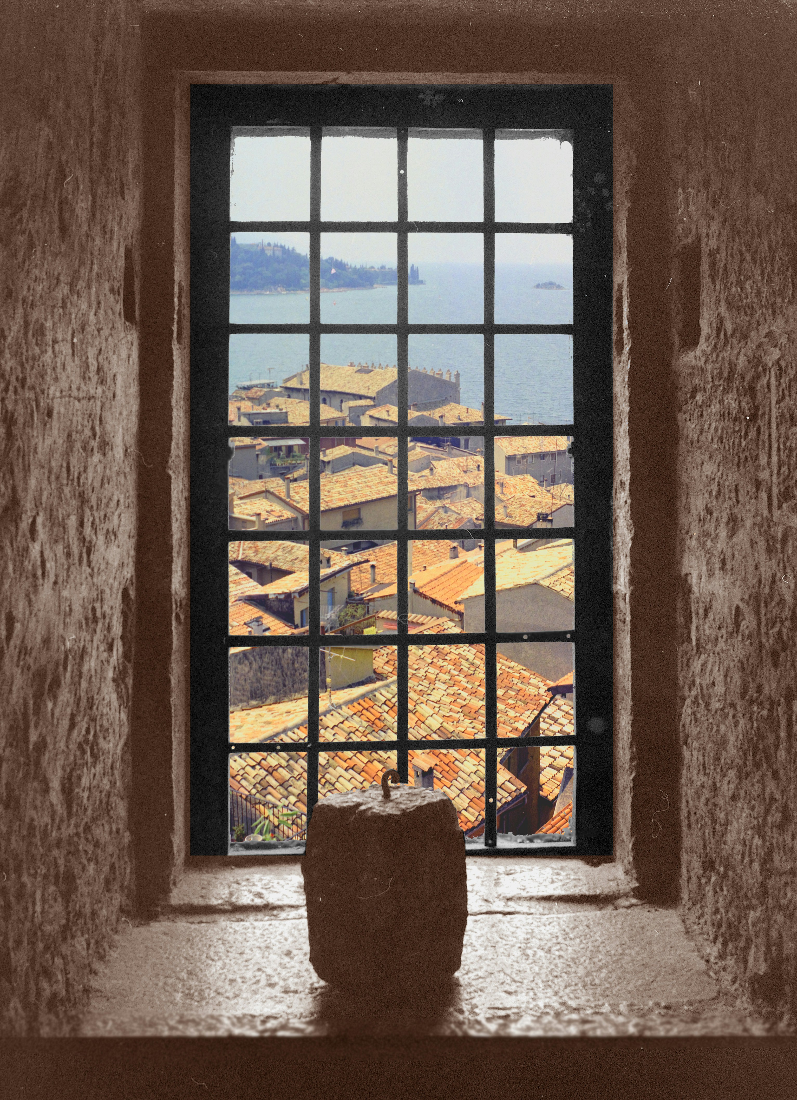 Framed Sunlit Rooftops: A Window into a Coastal Village