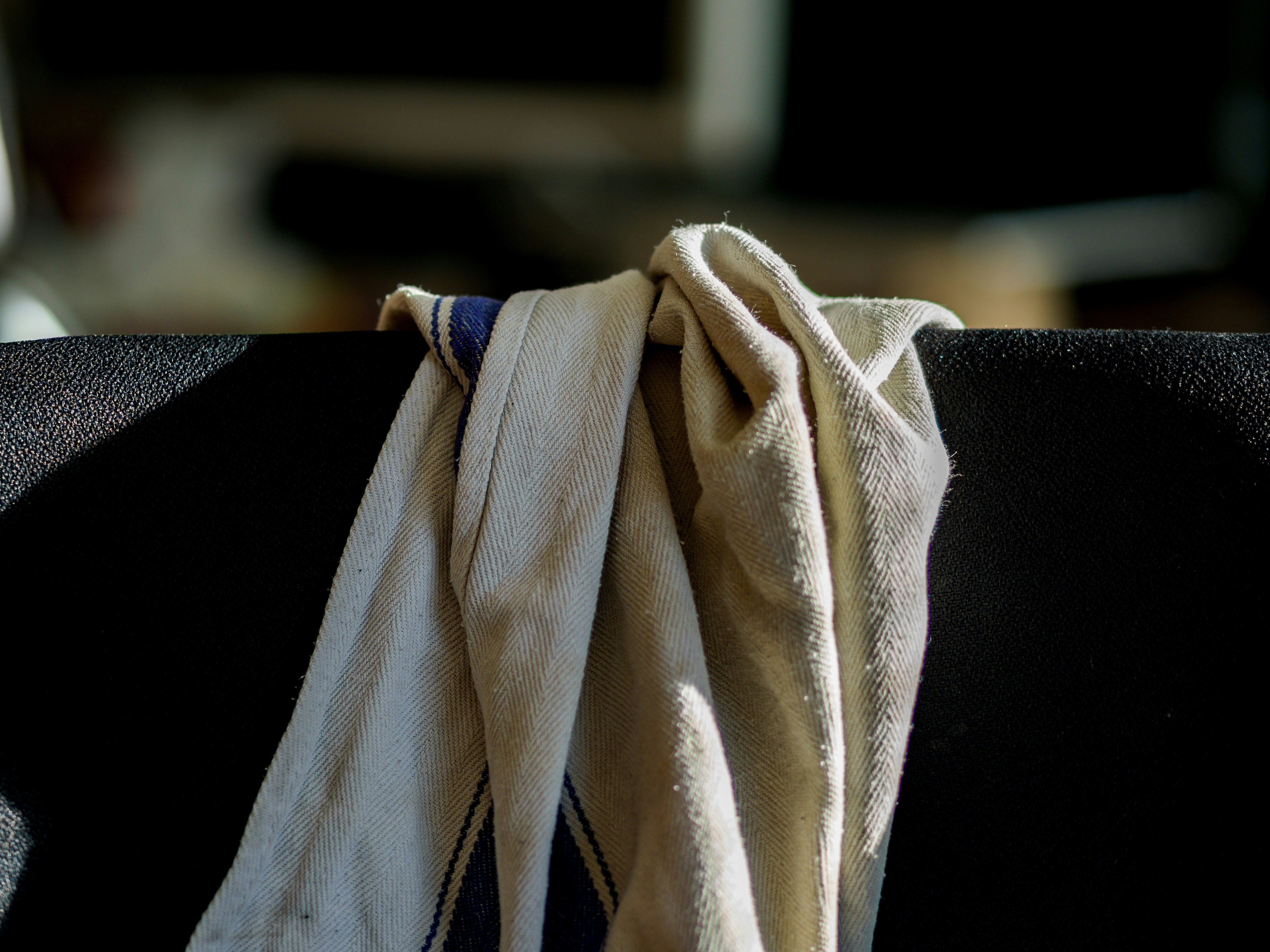 Two towels draped over a chair, showcasing the interplay of light and texture in a domestic setting.