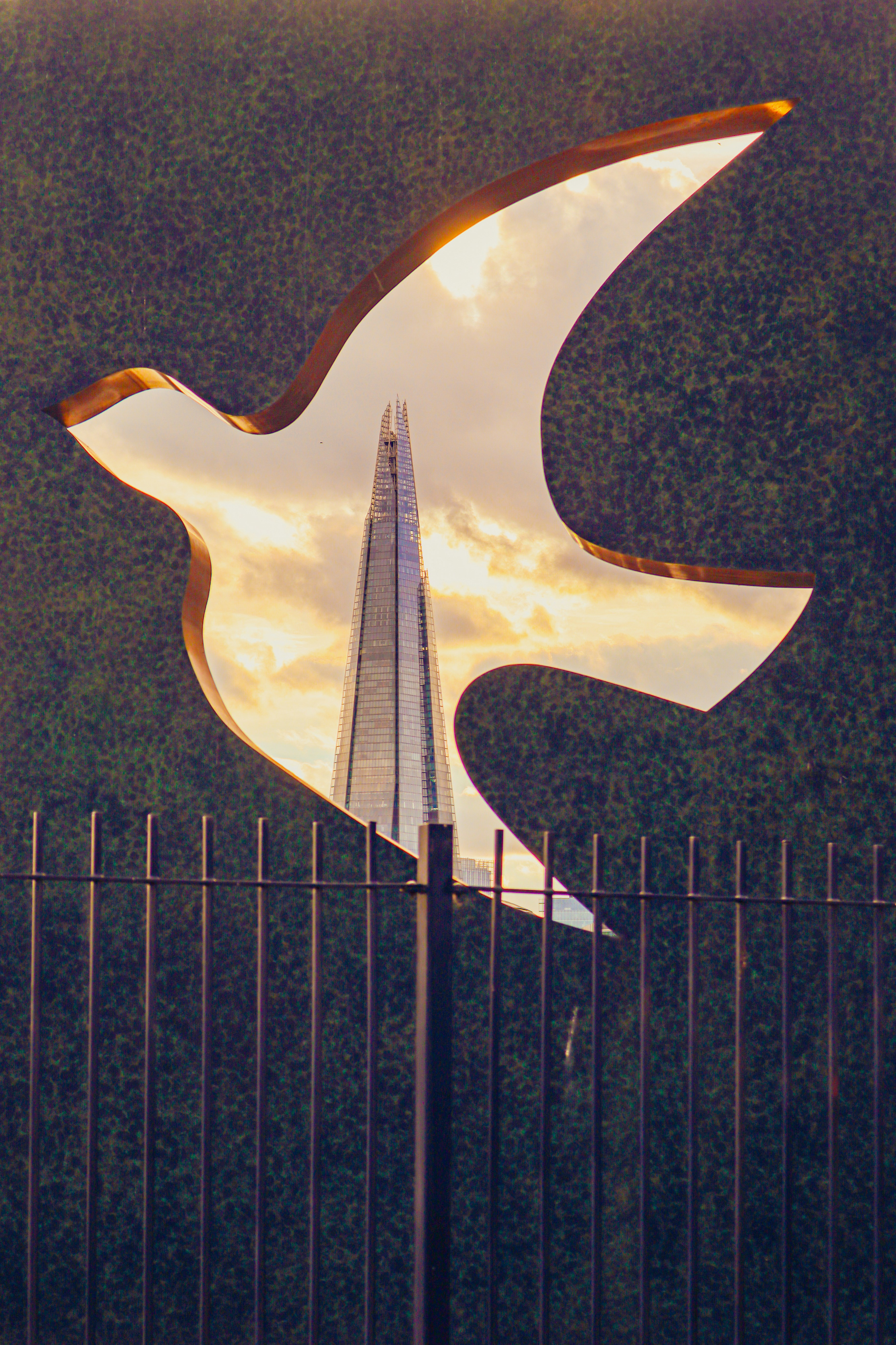 Copper-Trimmed Cutout Frames a Glass Spire at Sunset