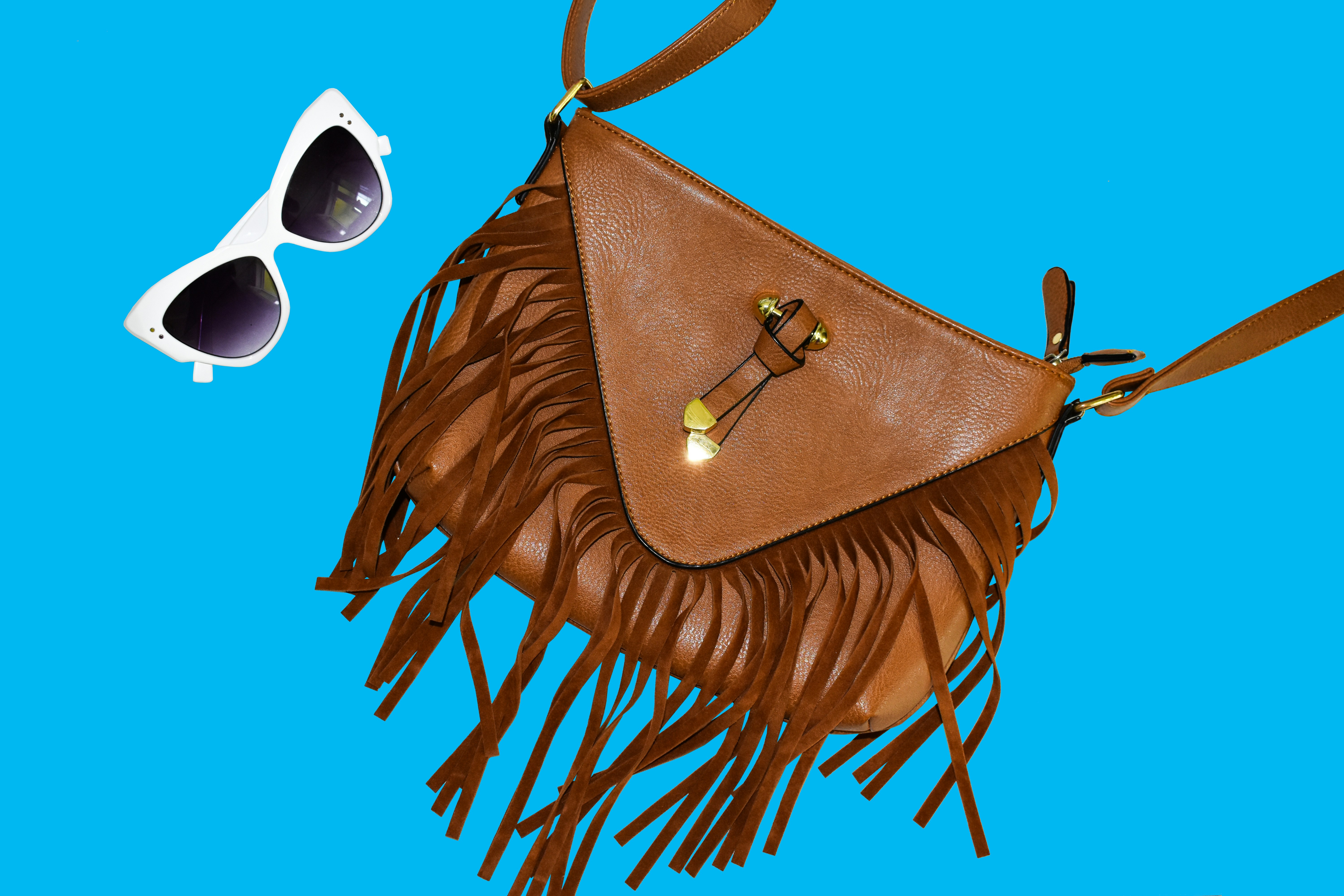 a brown purse with a pair of sunglasses on top of it