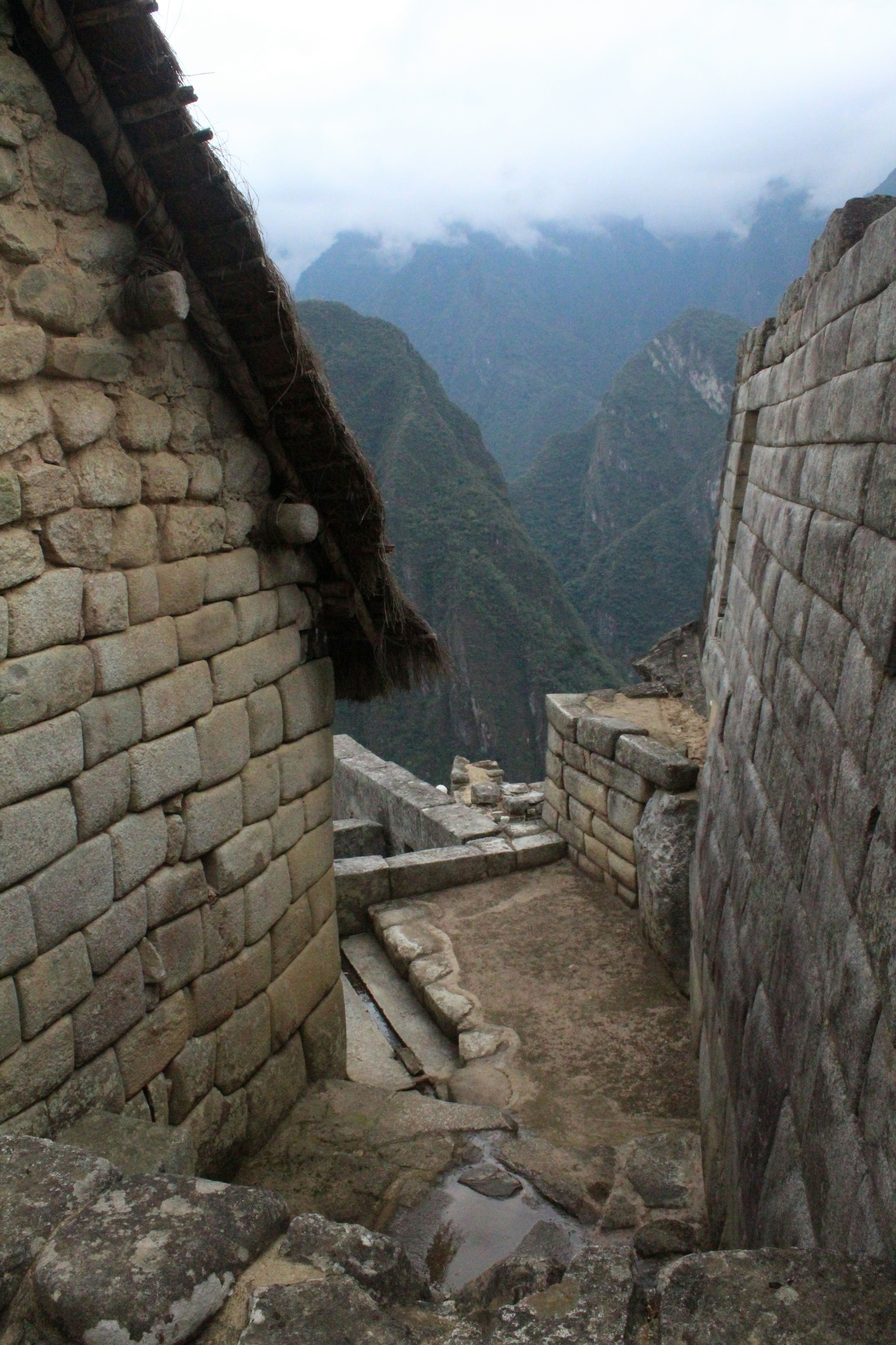 Un bâtiment en pierre avec un toit de chaume au sommet d’une montagne ...