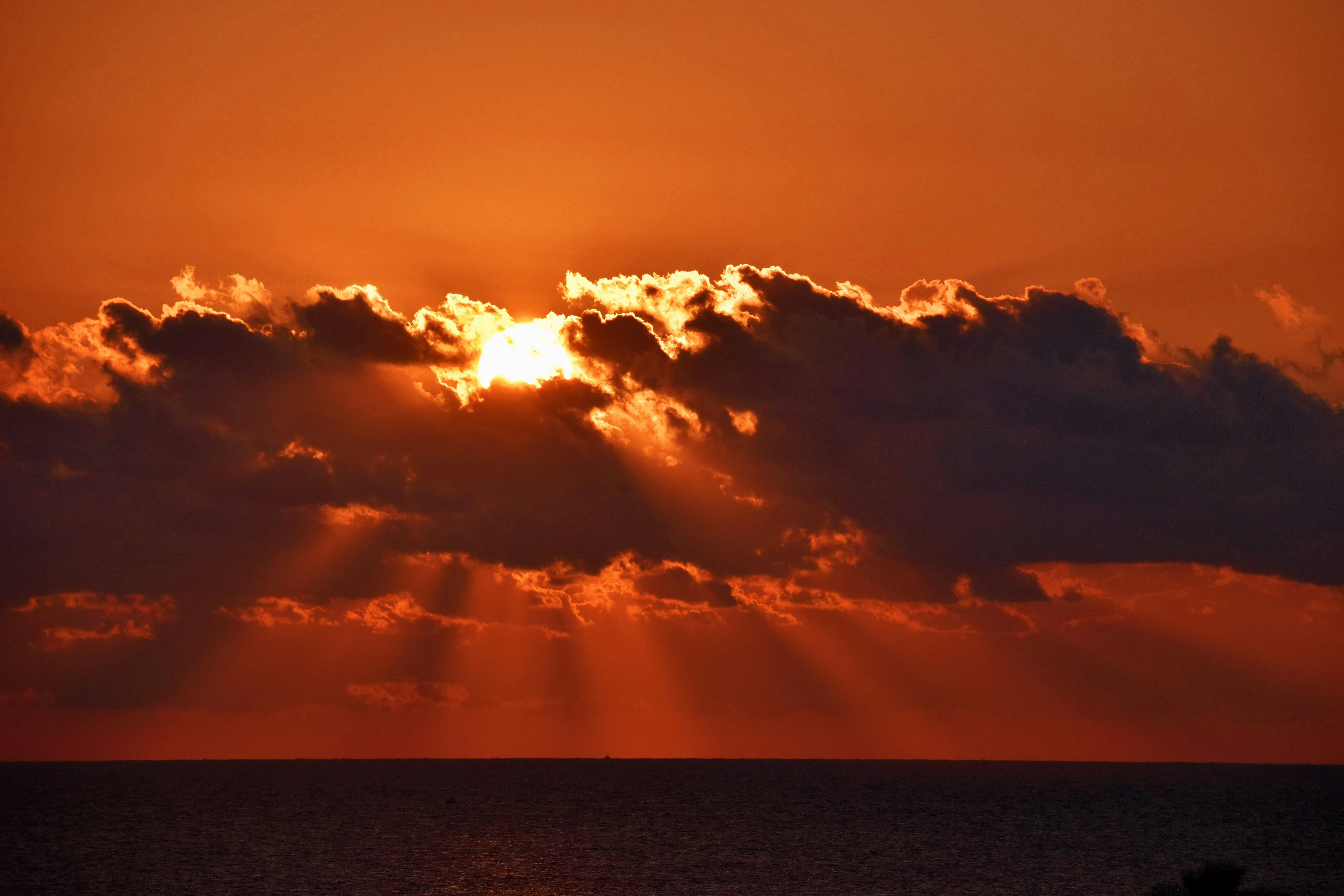 Foto El sol brilla a través de las nubes sobre el océano – Imagen Playa ...