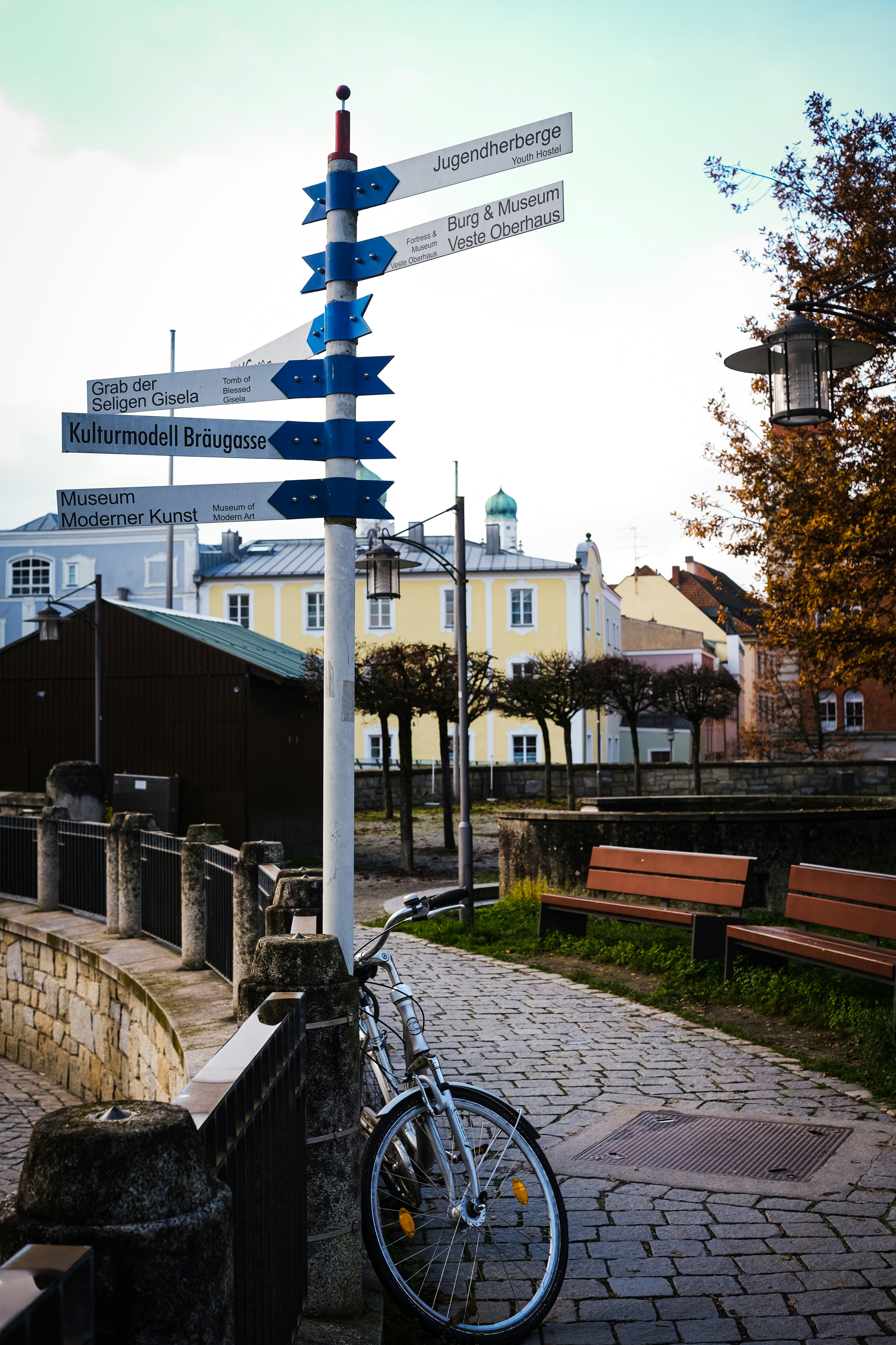 A bicycle leaning against a pole with street signs on it photo – Free ...