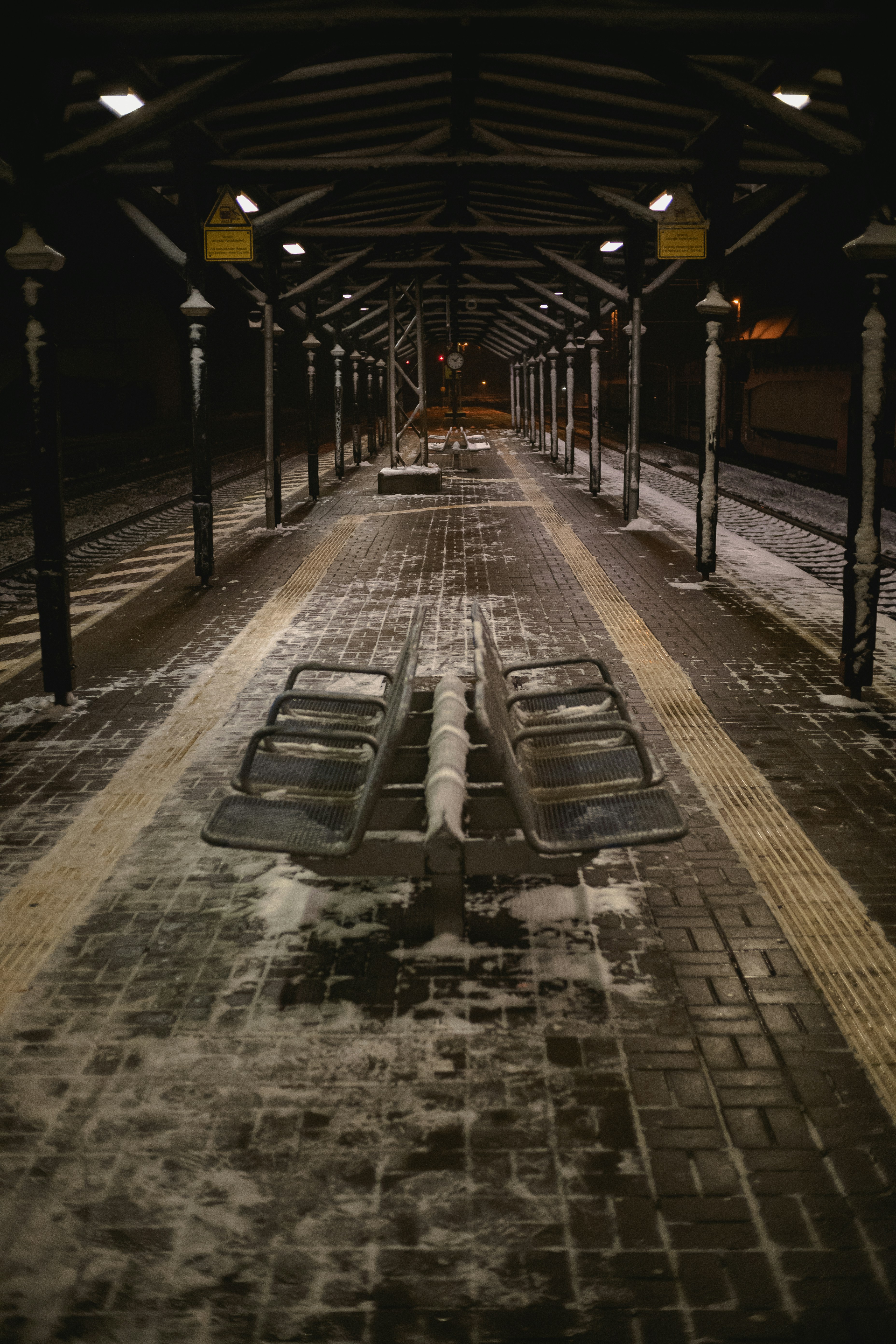 a train station covered in snow at night
