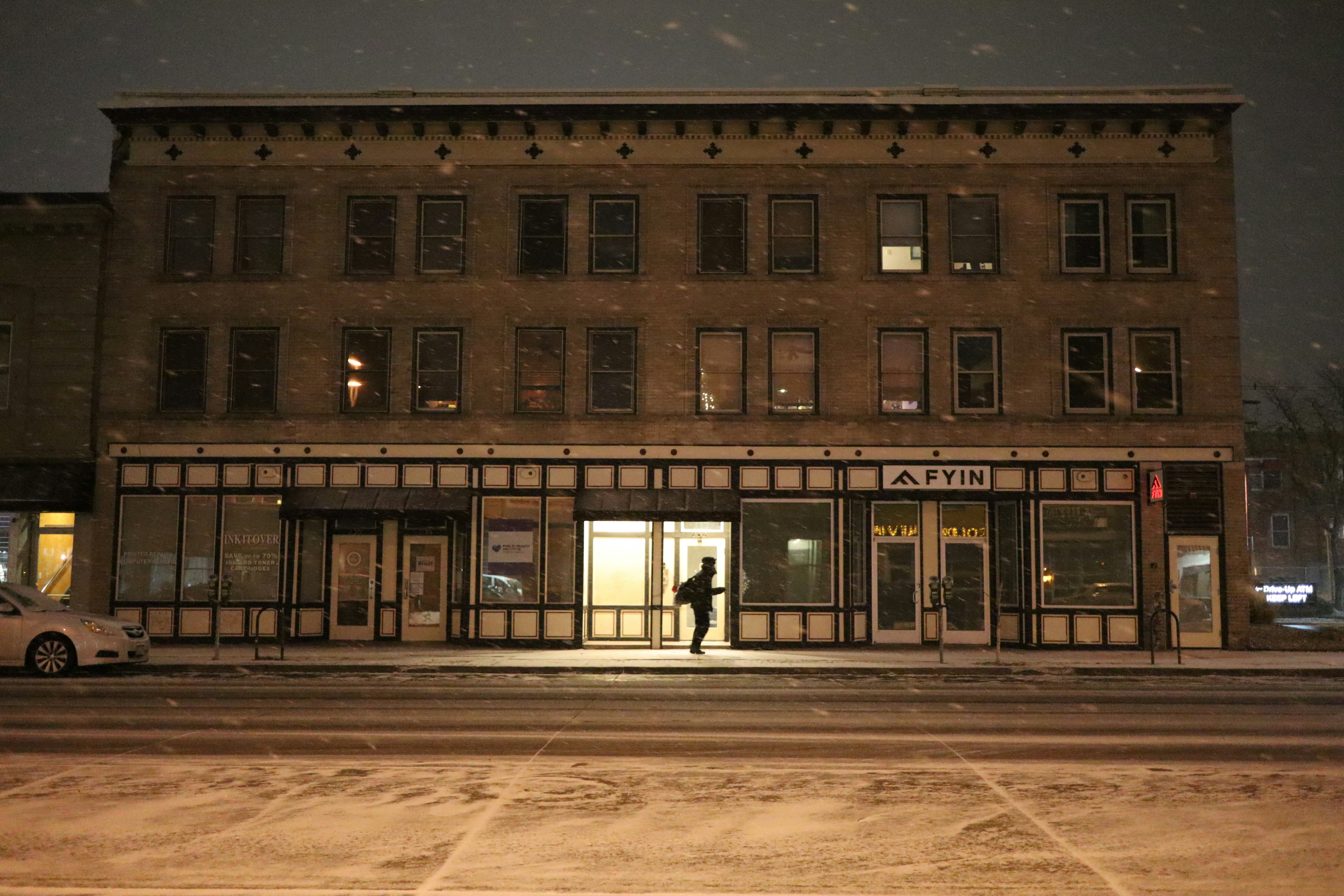 A person standing outside of a building at night photo – Free City ...