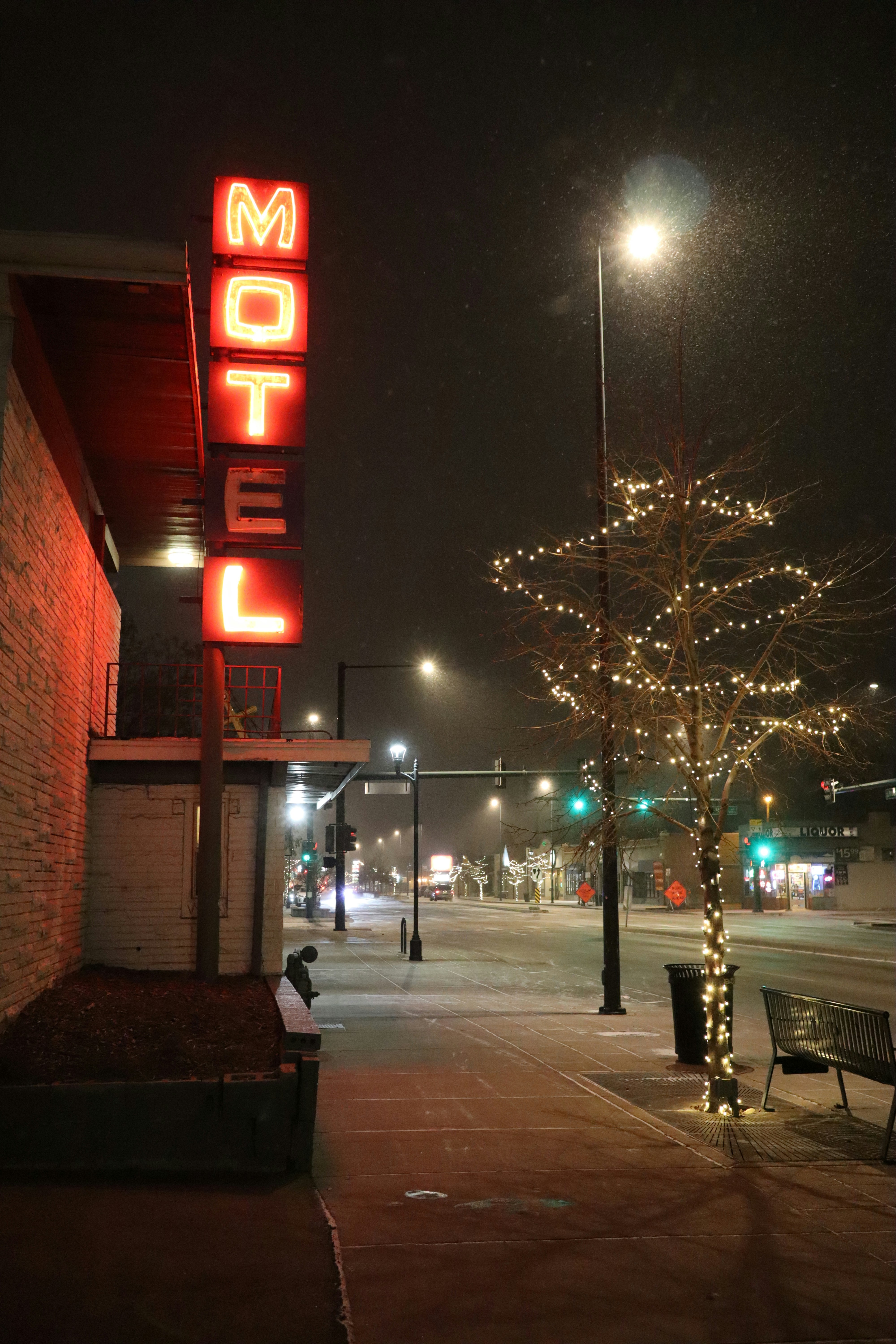 A motel sign lit up at night on the side of a street photo – Free Neon ...