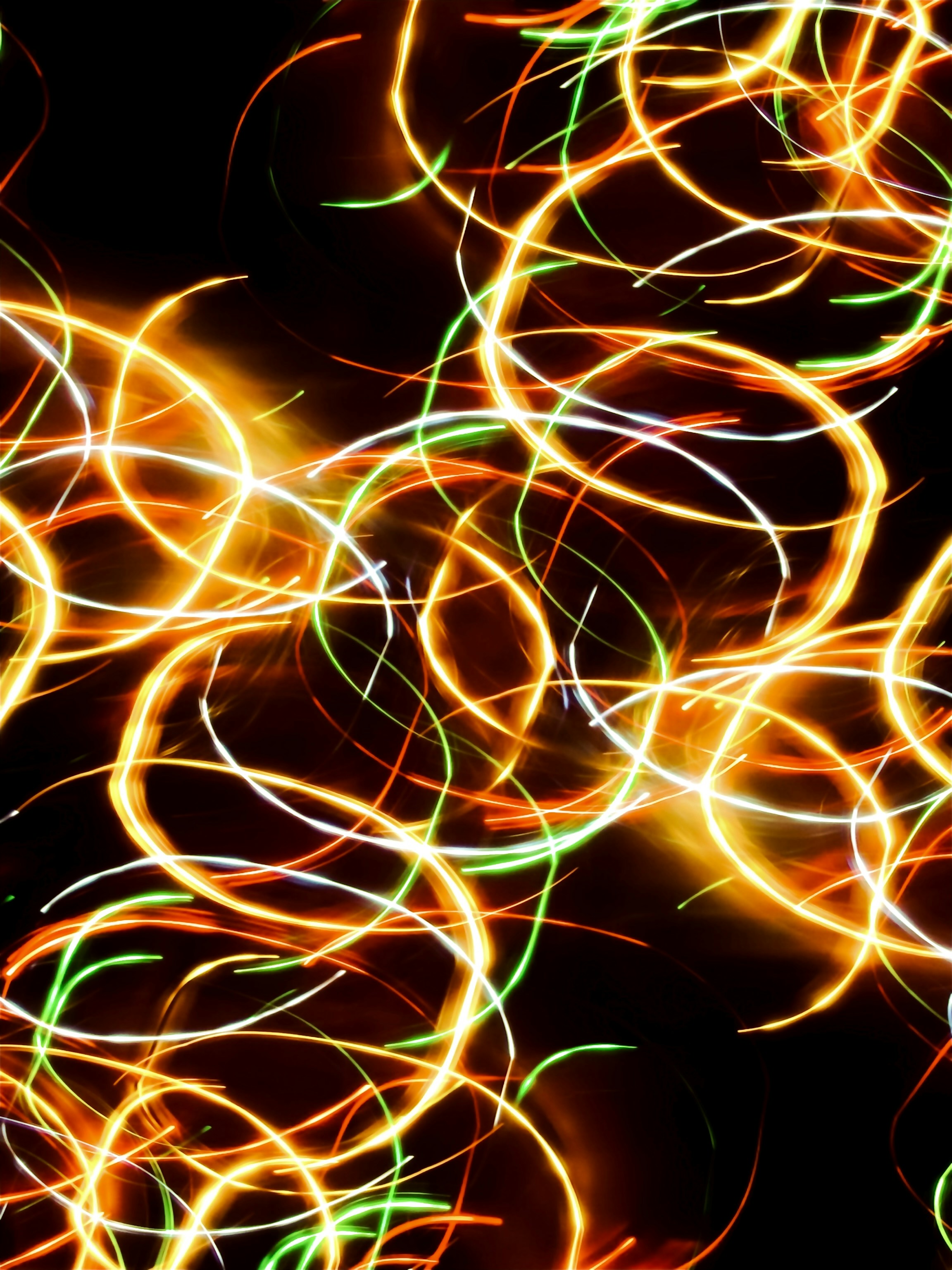 Abstract composition of swirling light trails in vibrant colors against a dark background.