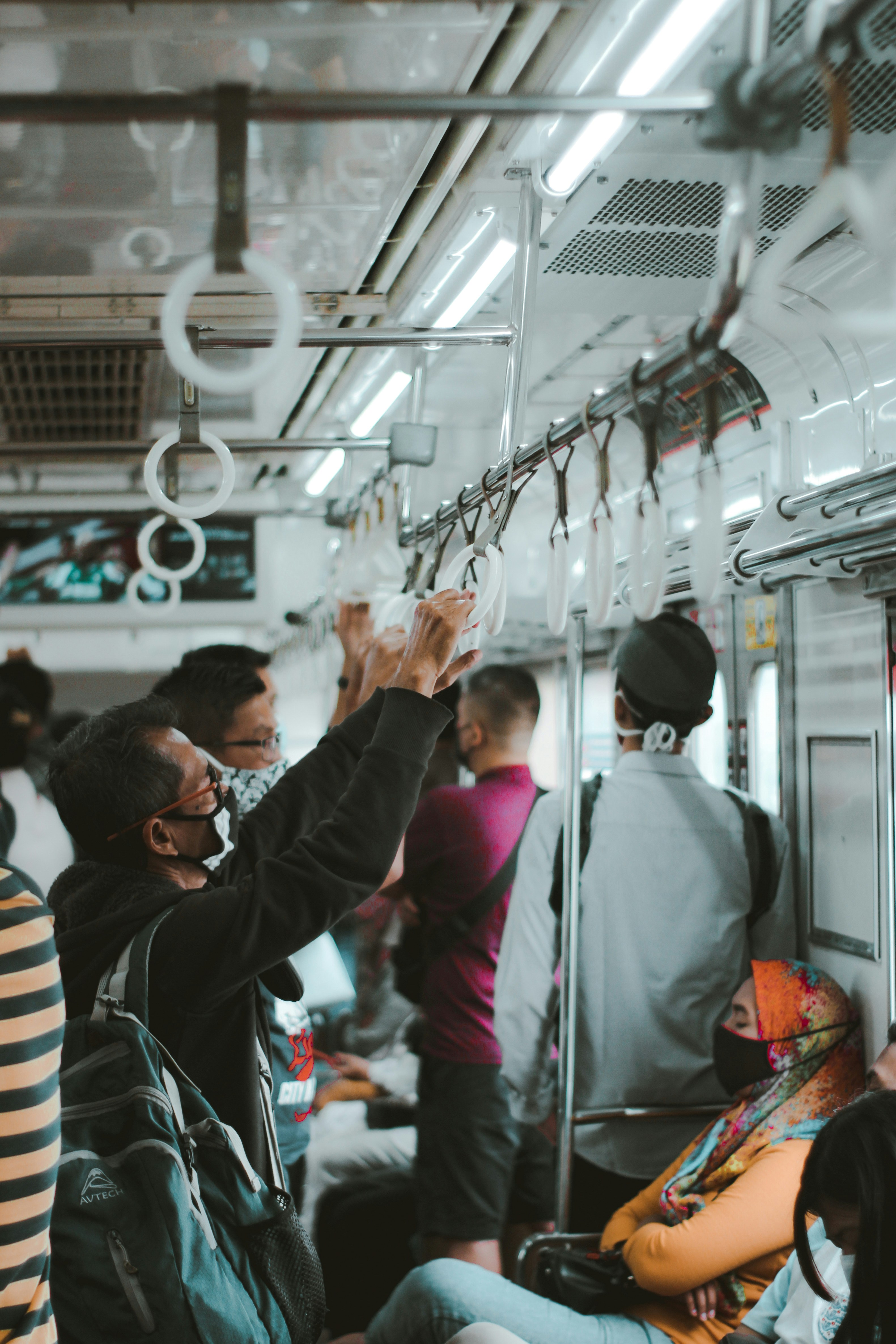 A group of people riding on a train next to each other photo – Free ...