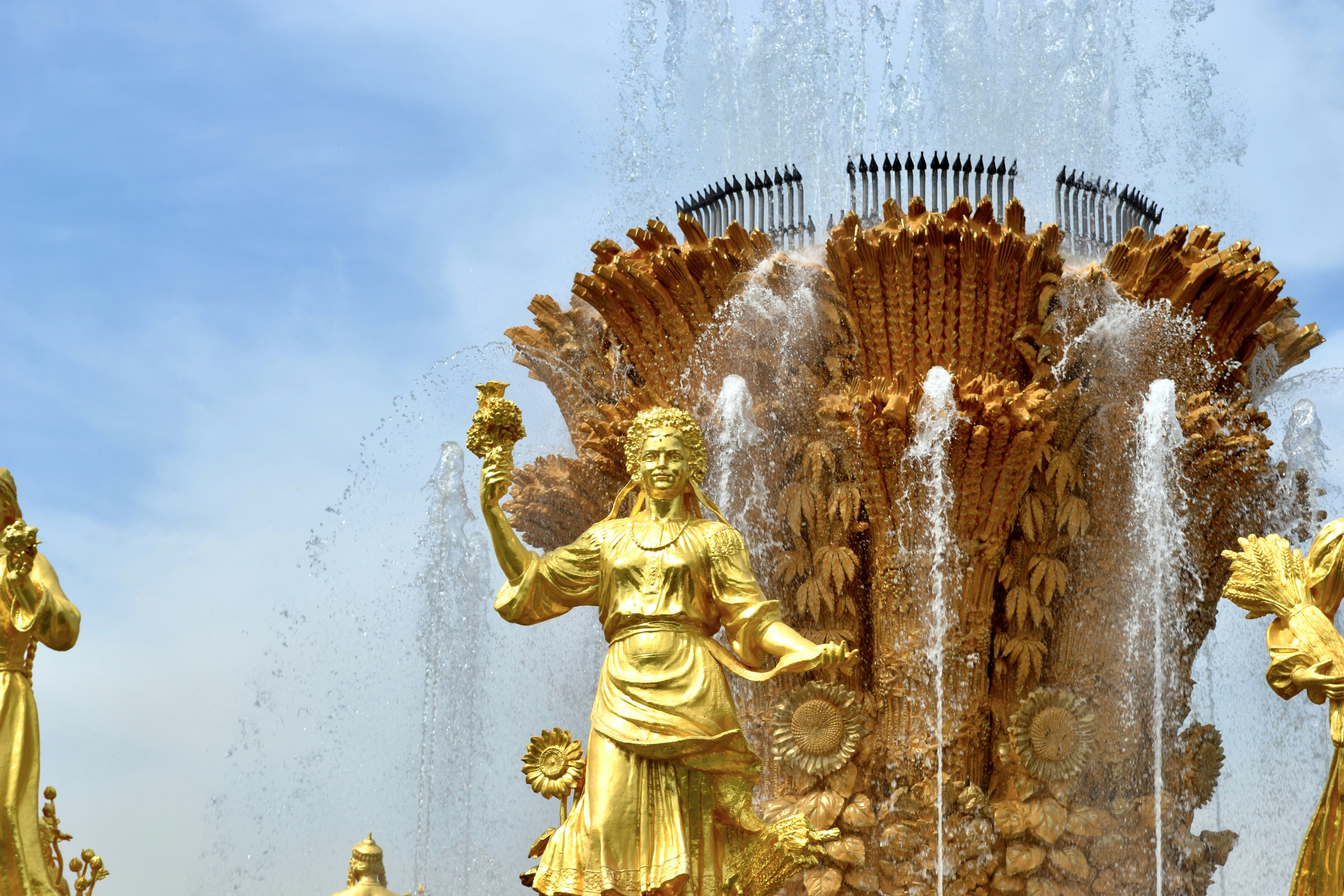 A fountain with gold statues and water spouting out of it photo – Free ...