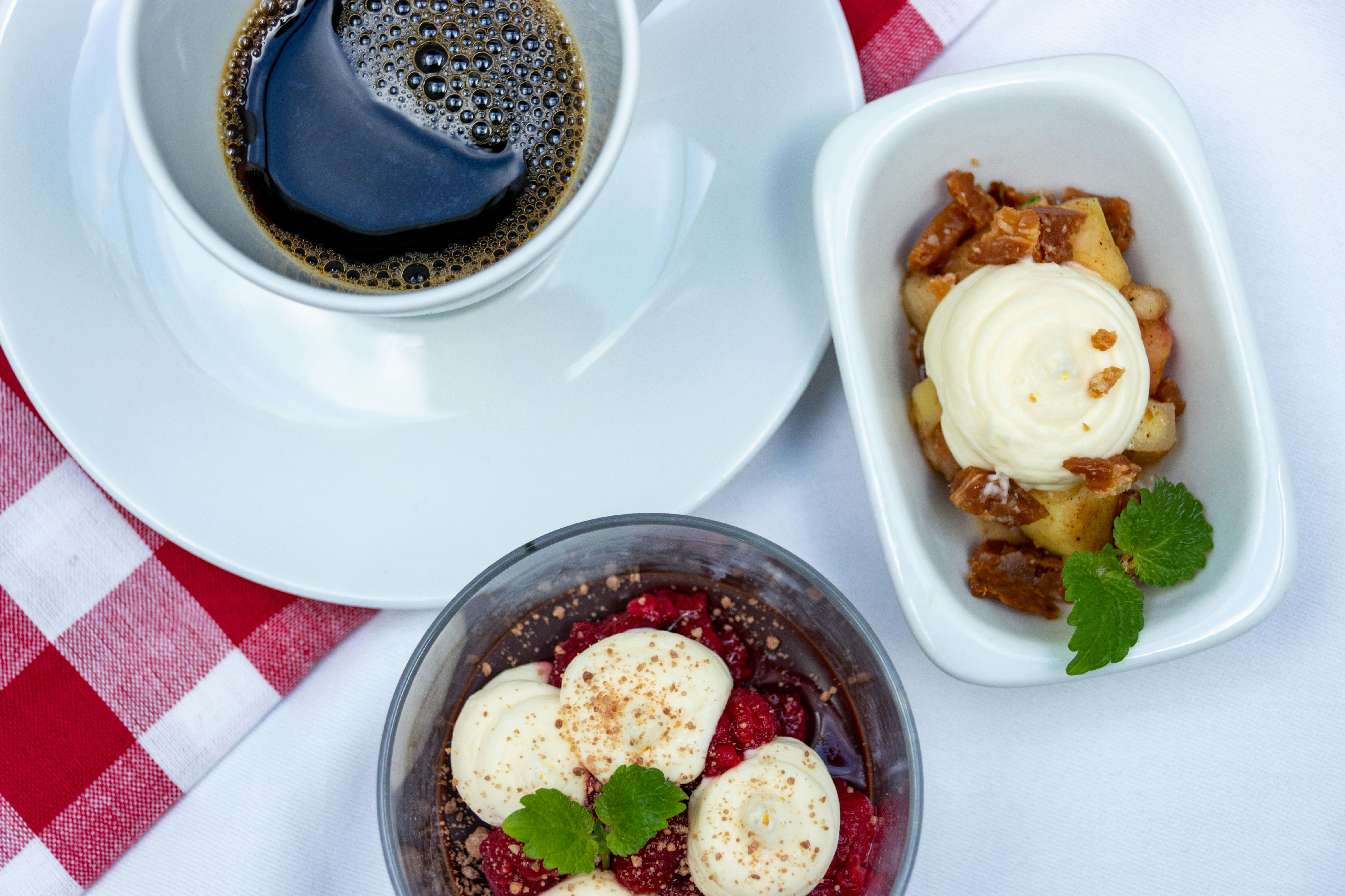 a cup of coffee next to a bowl of fruit