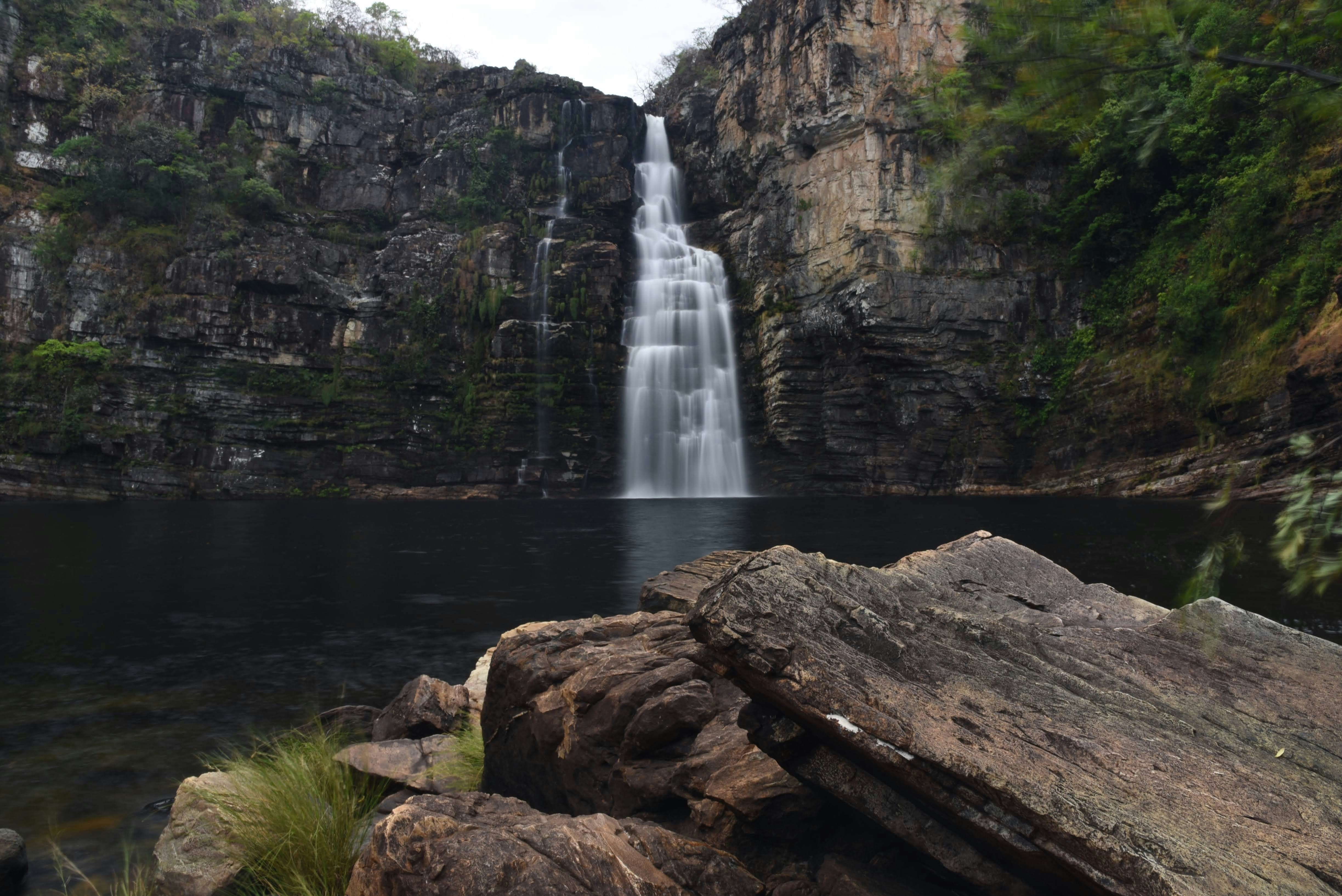A waterfall with a large rock in front of it photo – Free Backgrounds ...