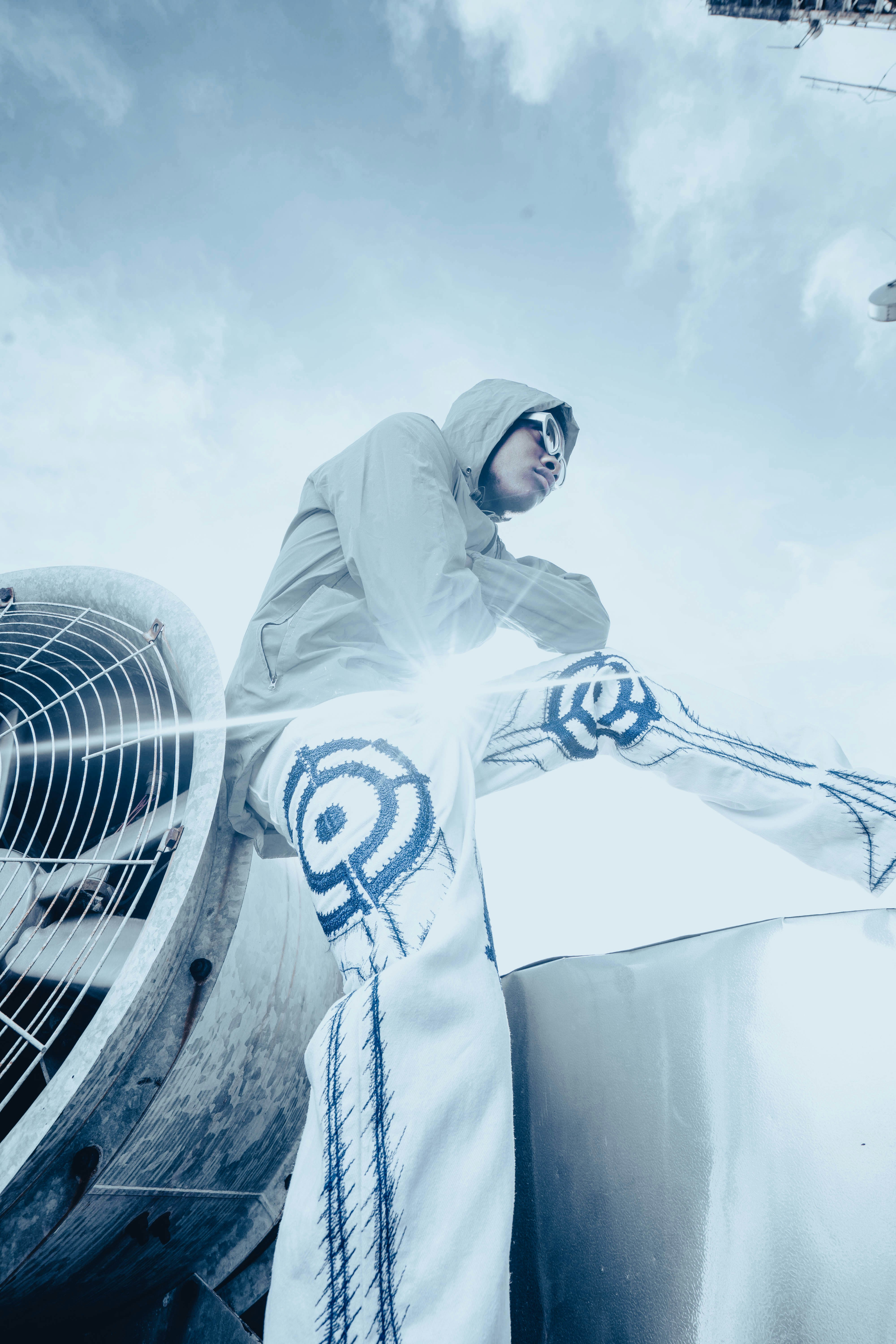 Venturer Above the Rooftop: A Hoodie-Clad Gaze Against the Sky