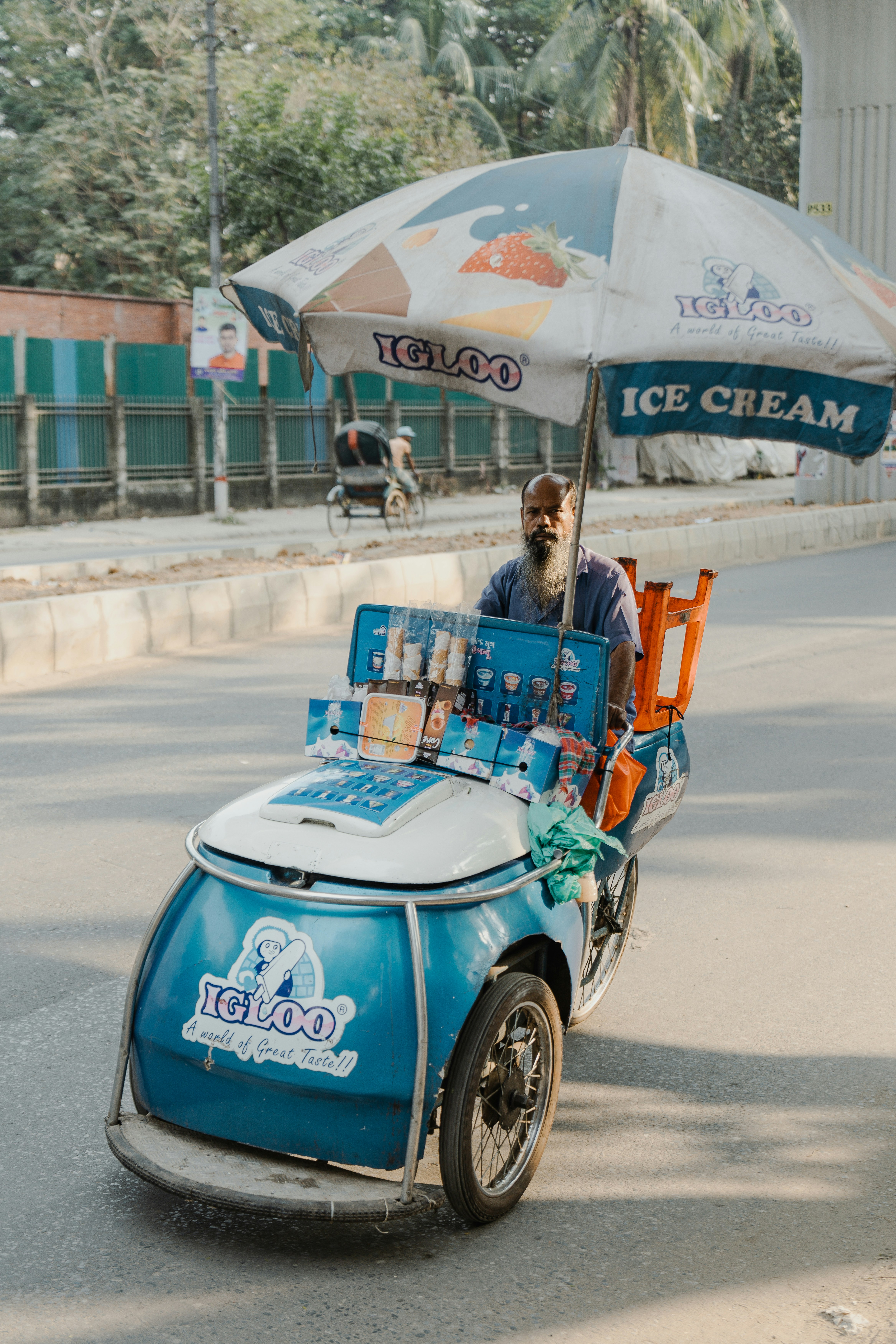 Blue Parasol Vendor: Ice-Cream Cart on a Sunlit Street