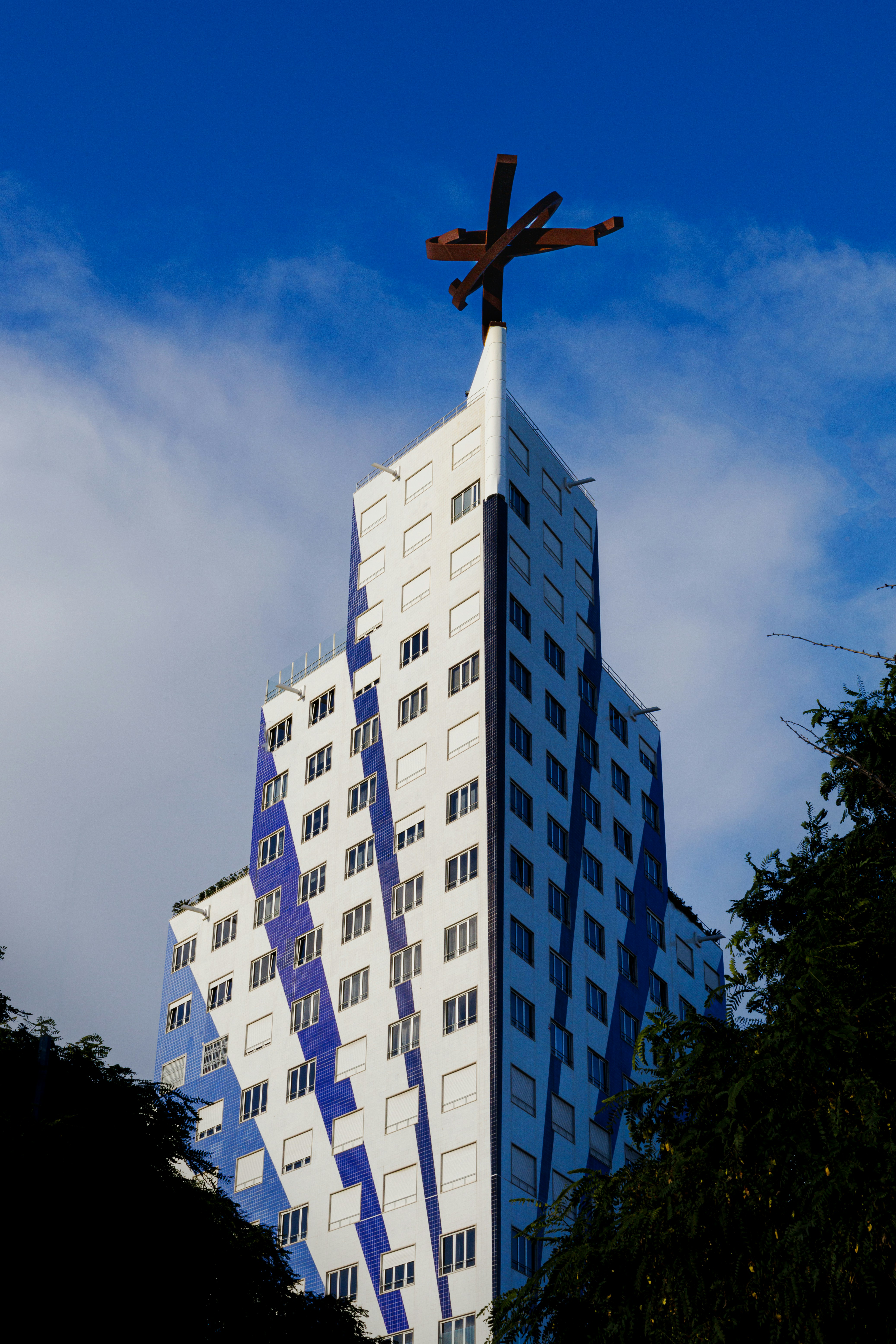 Foto Un edificio alto con una cruz encima – Imagen Fotografía callejera ...