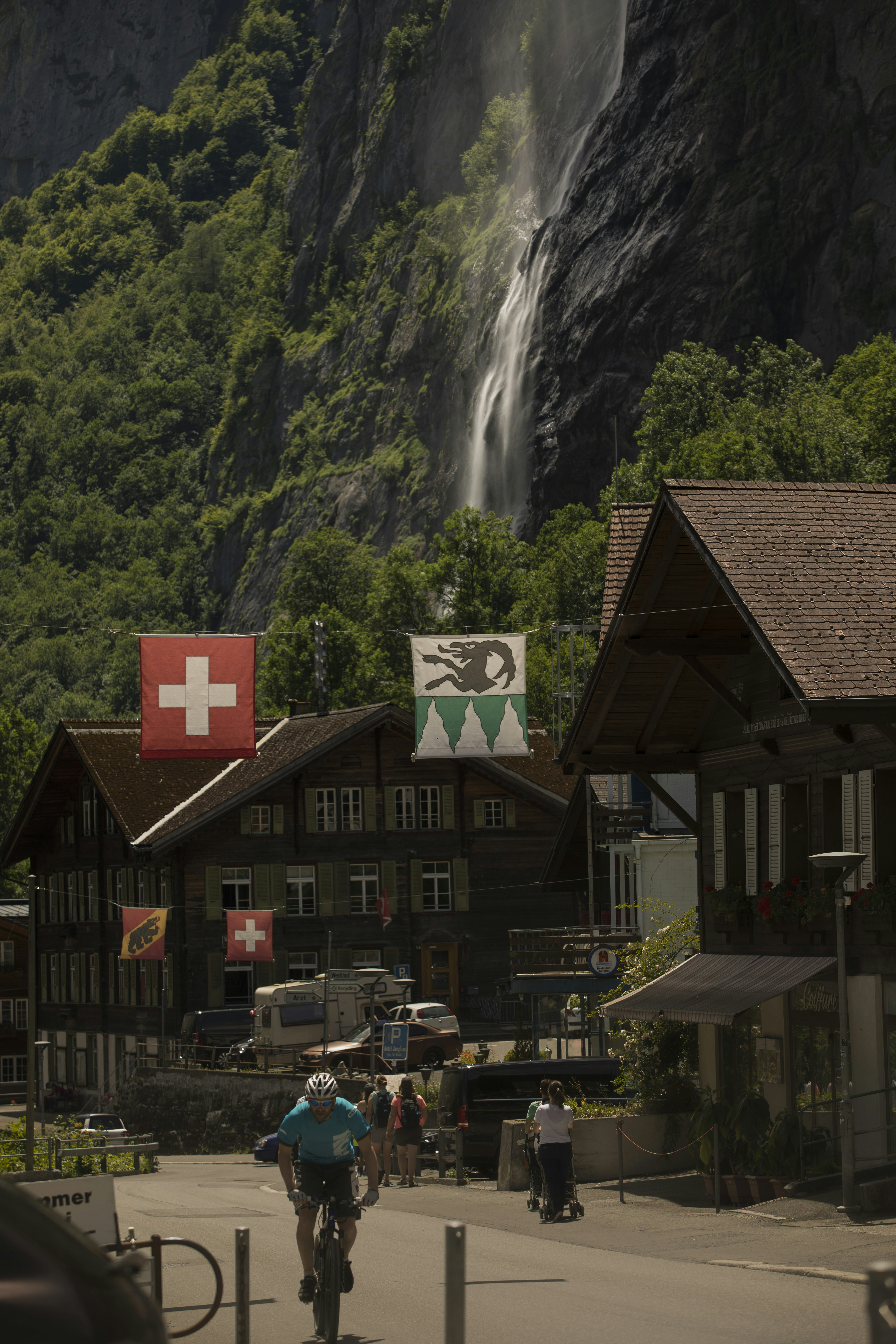 a man riding a motorcycle down a street next to a waterfall