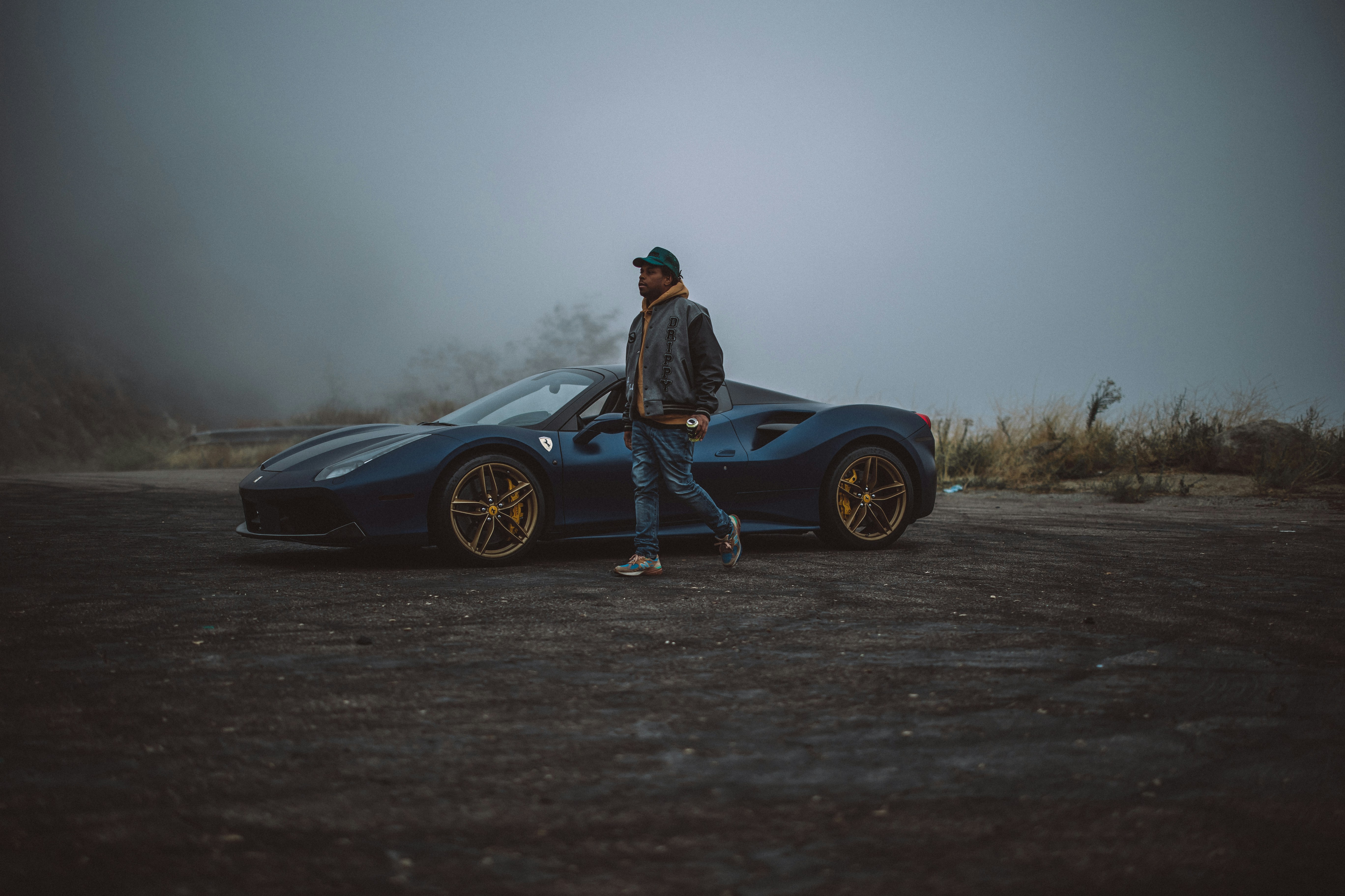 Fogbound Contrast: A Lone Walker beside a Cobalt Blue Sports Car