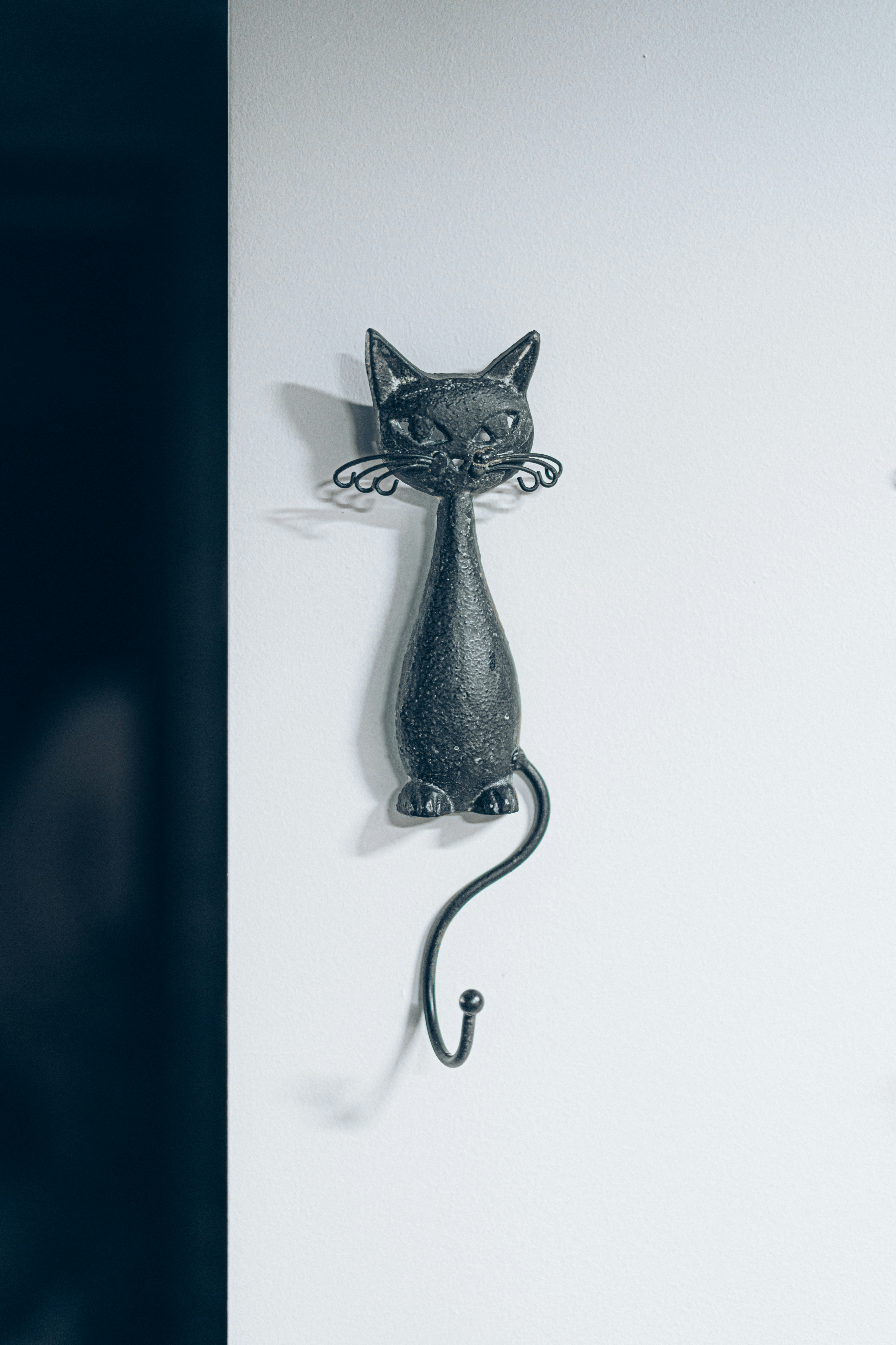 a black cat figurine hanging on a wall