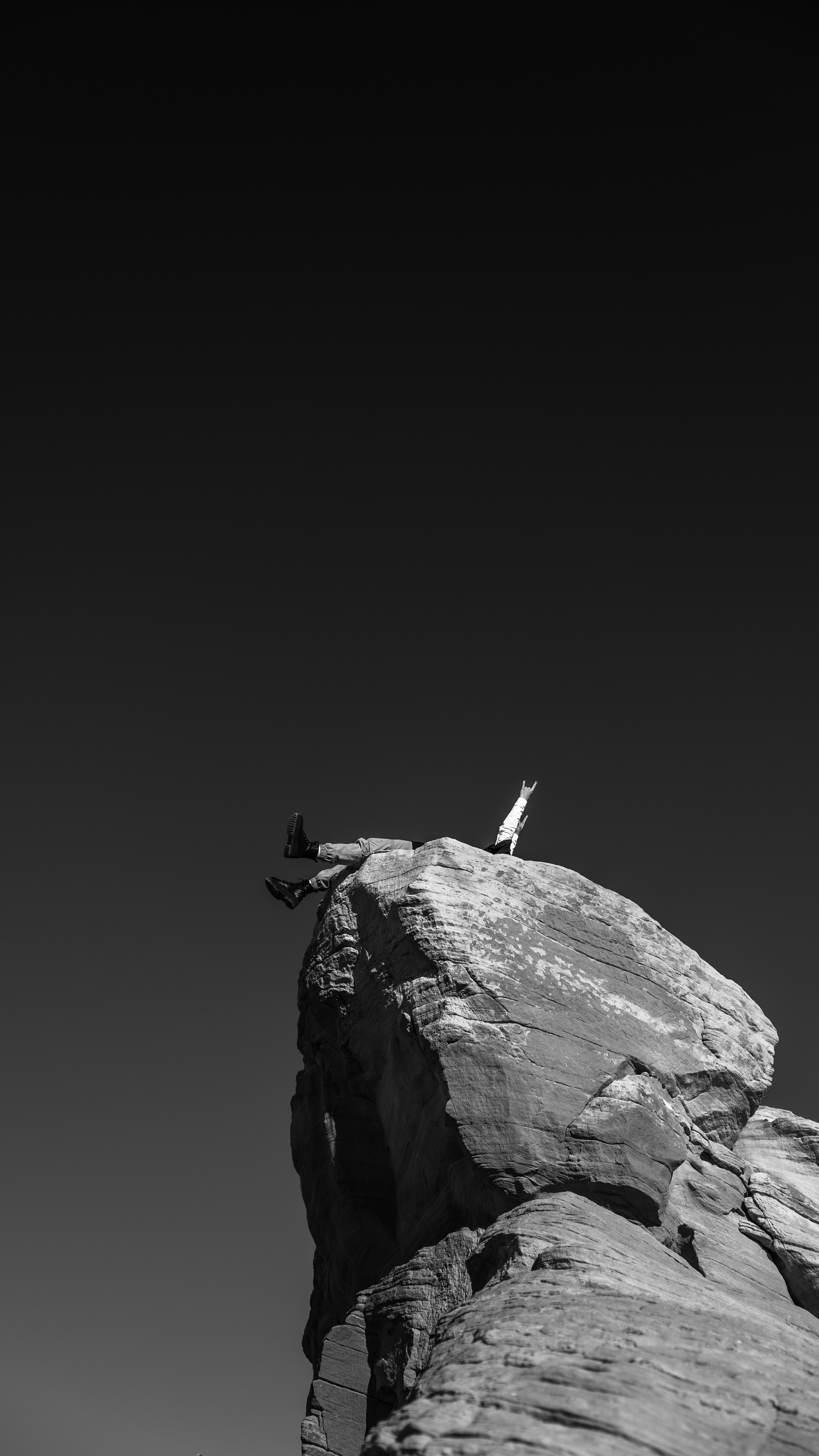 Edge Above Darkness: Two climbers atop a granite pinnacle under a vast sky