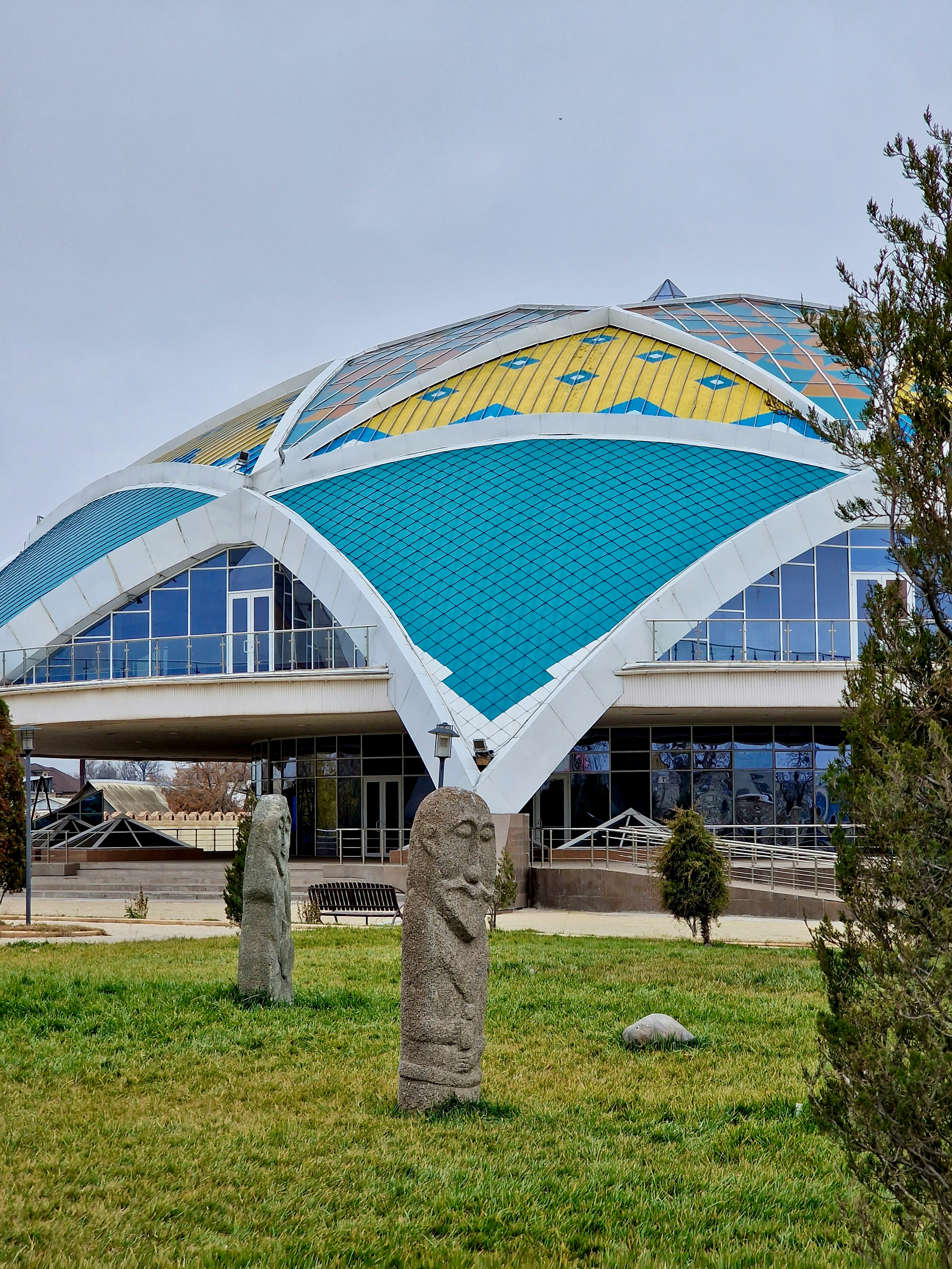 Azure Arches Over Glass: A Modern Pavilion Framed by Stone Sentinels