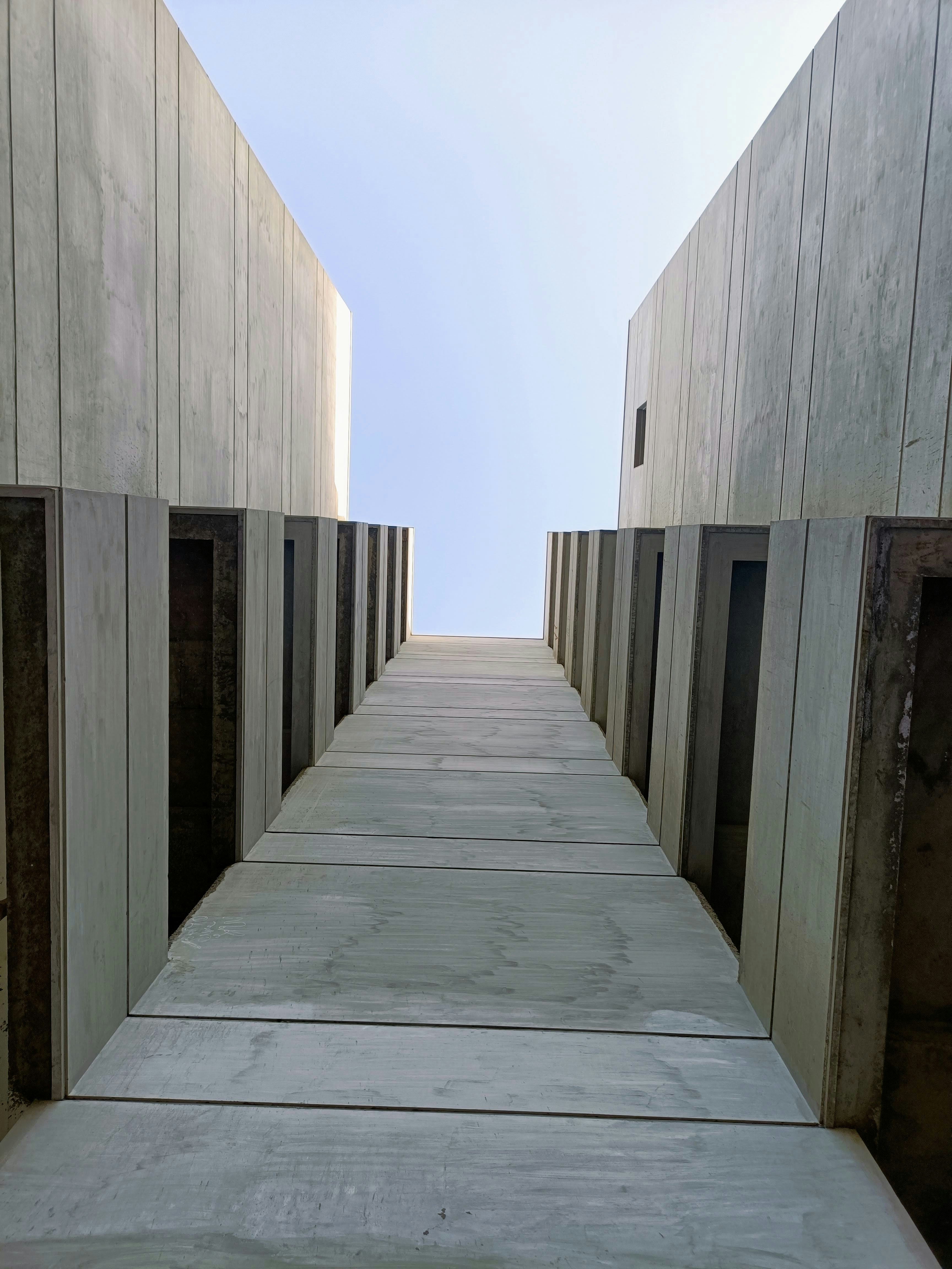 Une passerelle en béton entre deux bâtiments avec un ciel en arrière ...