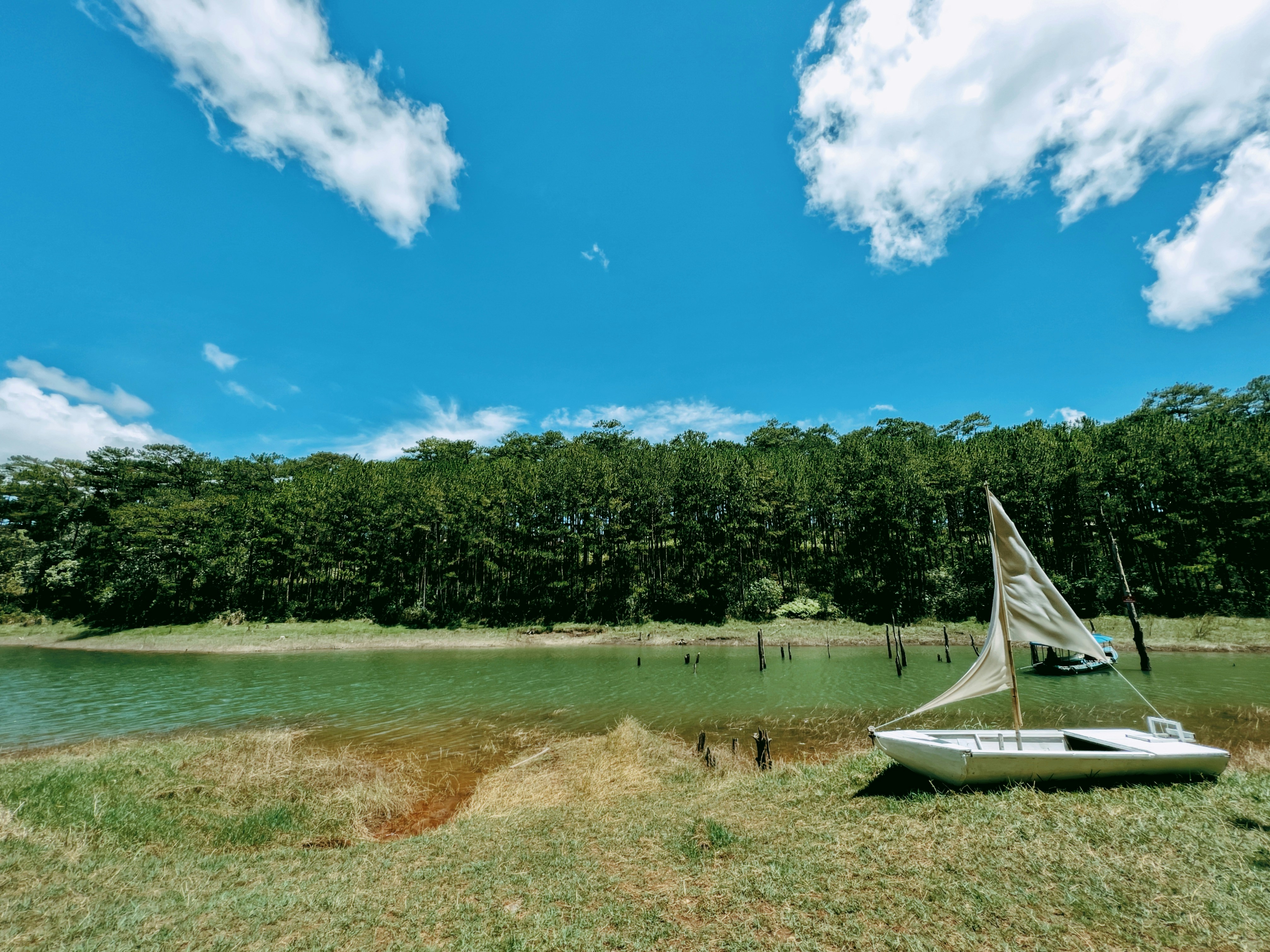 a sailboat sitting on the shore of a lake