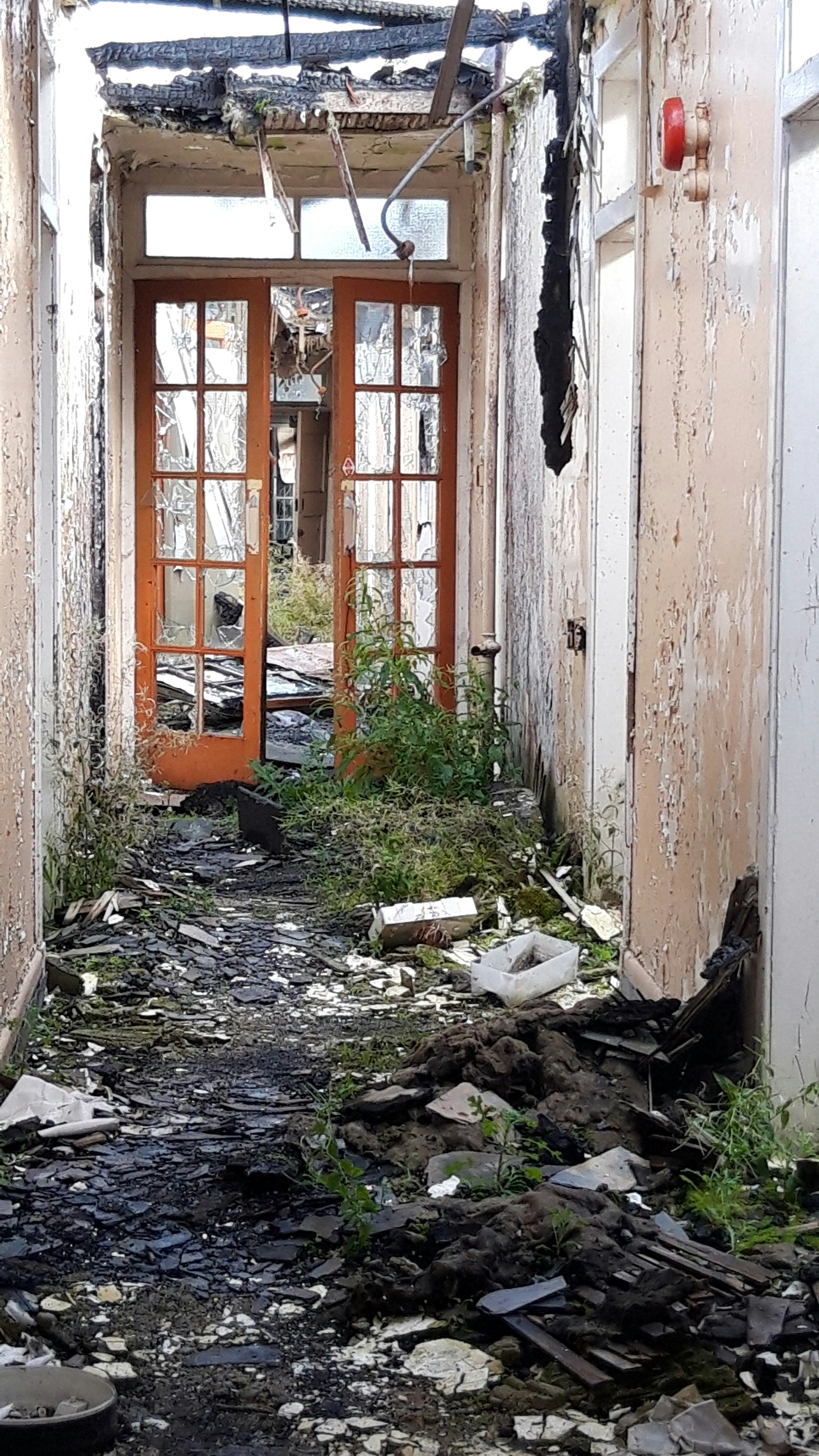 A hallway in an abandoned building with broken doors photo – Free ...