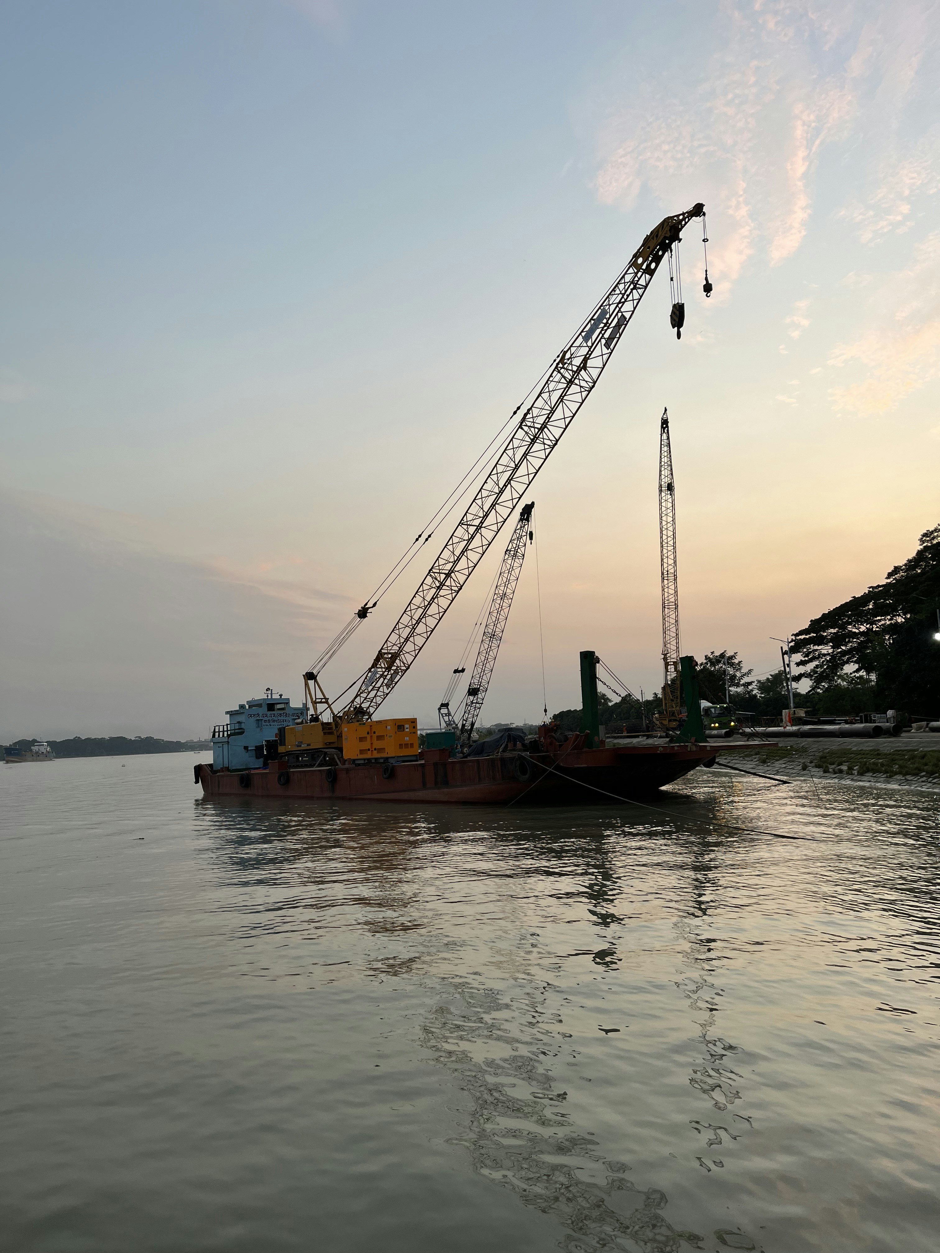 A crane is lifting a boat out of the water photo – Free Construction ...
