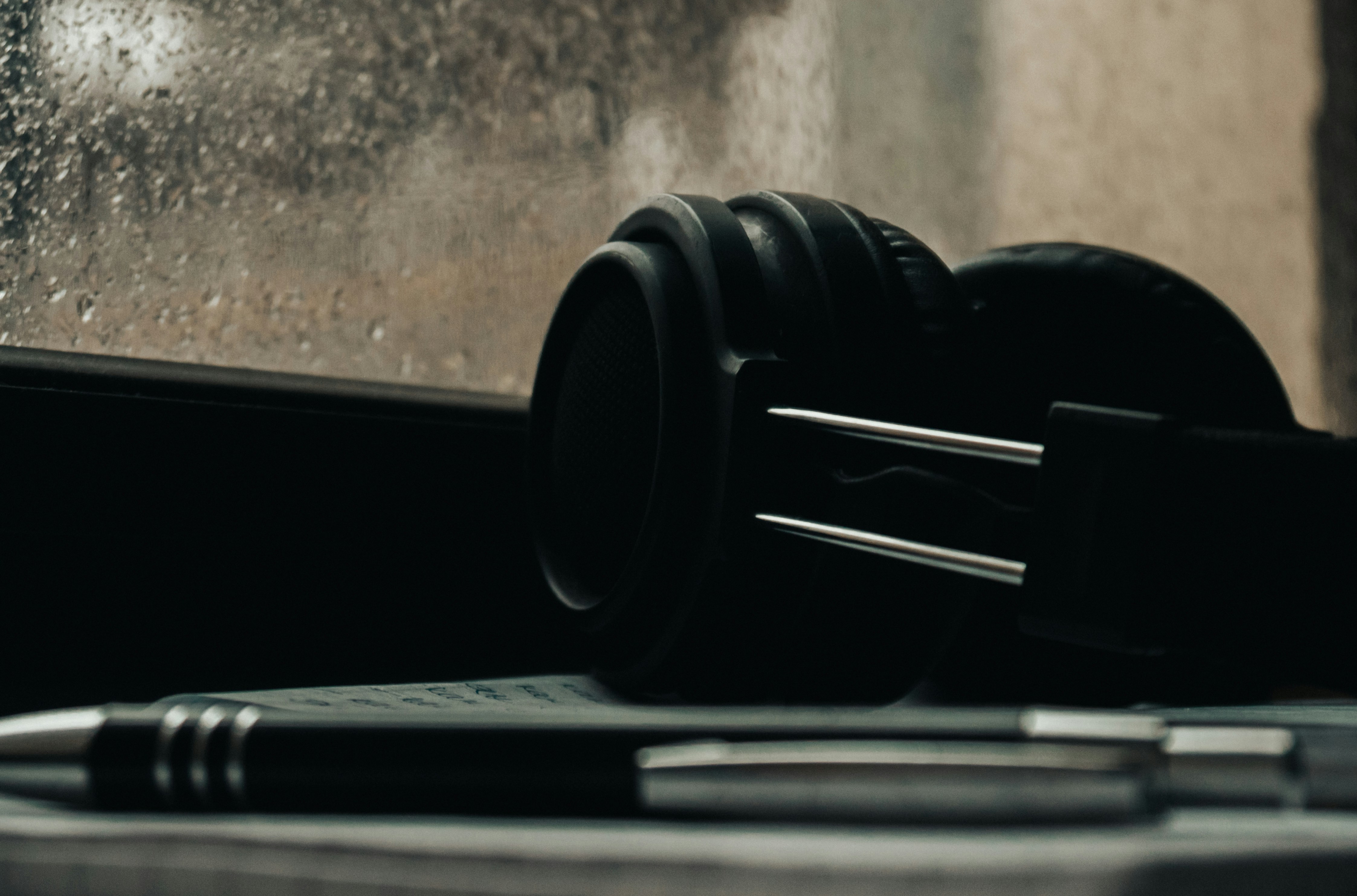 A pen and headphones on the notebooks for study