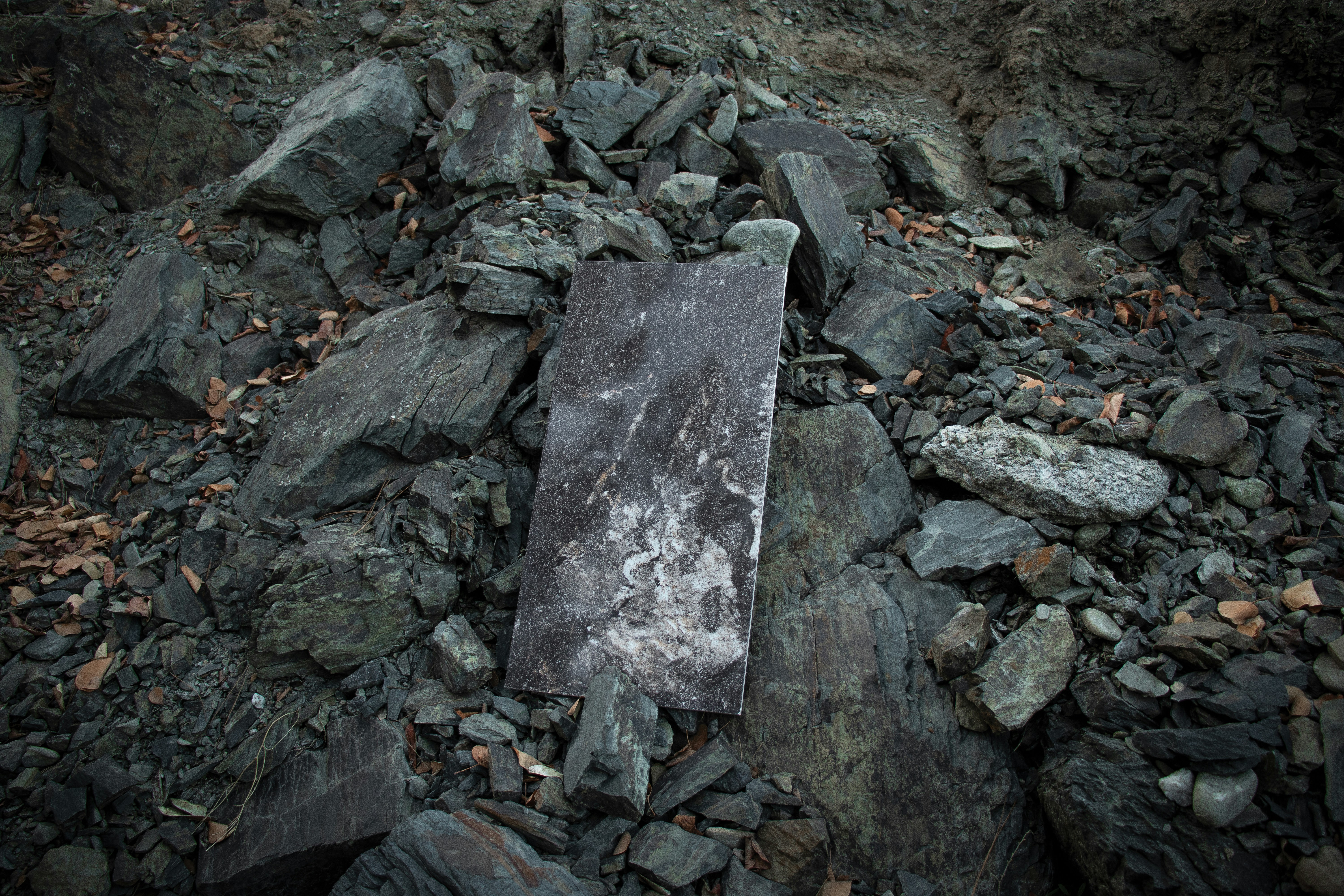 Foto Un pedazo de metal sentado encima de una pila de rocas – Imagen ...